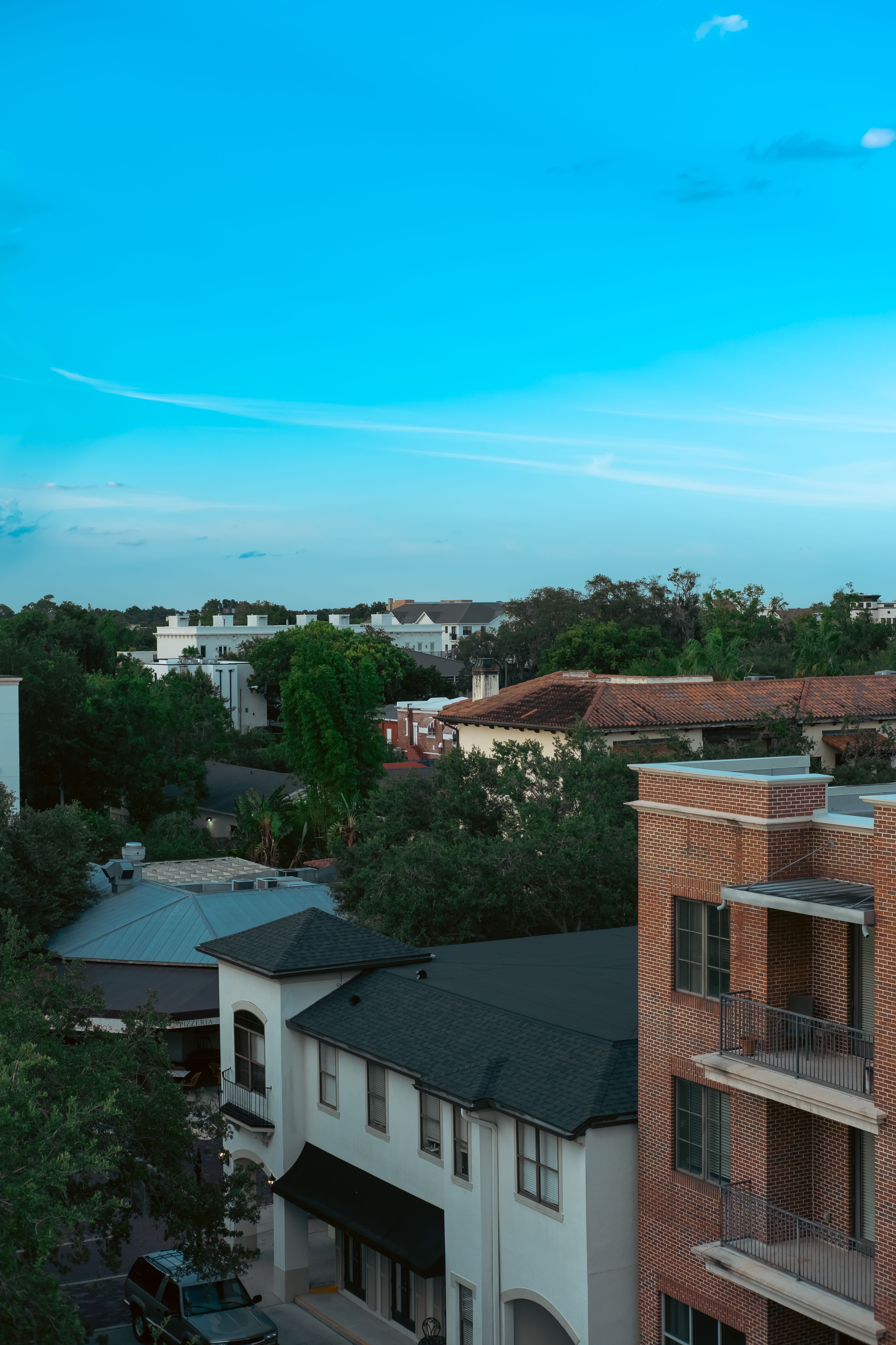 An Aerial Photography of Houses Near the Green Trees Under the Blue Sky ...