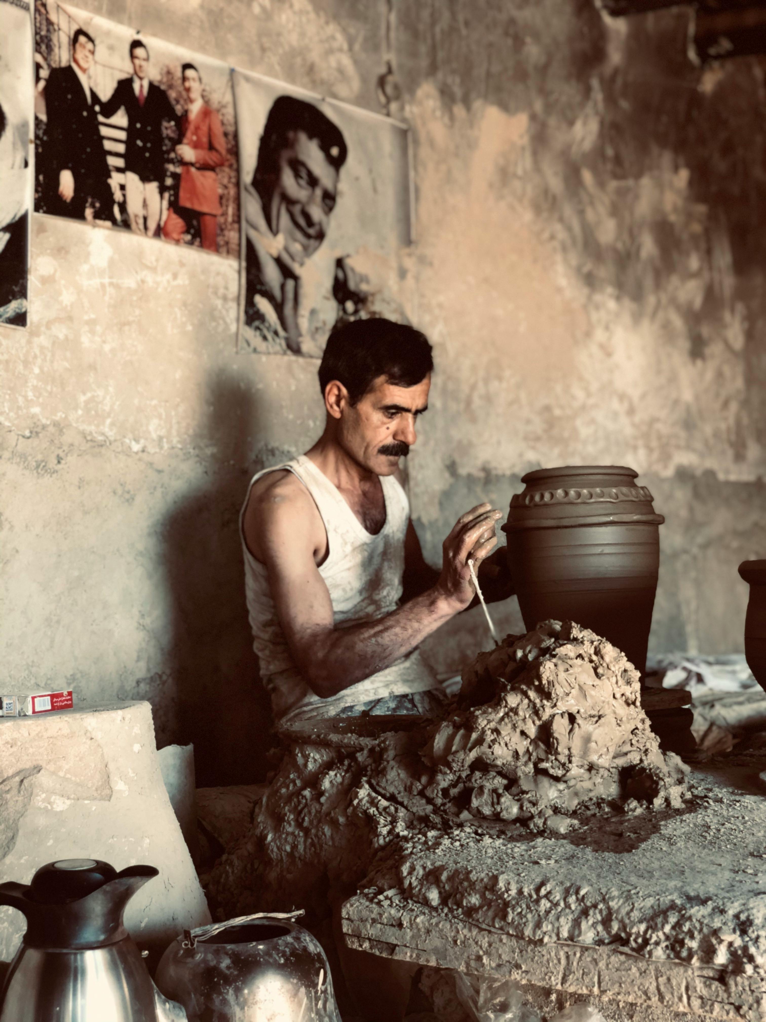 A Man in a Tank Top Doing Pottery · Free Stock Photo