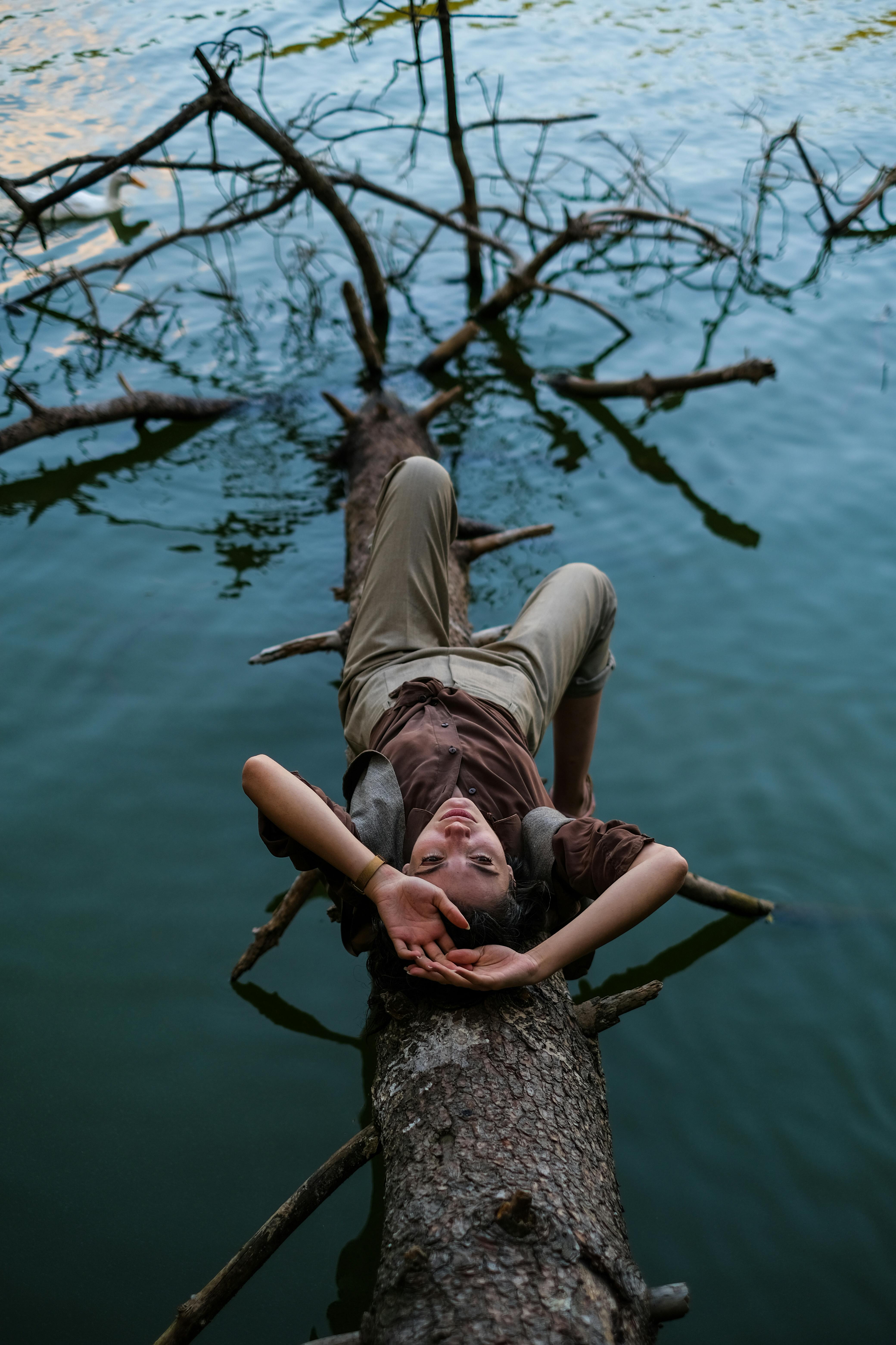 Woman Lying Down on a Tree Trunk · Free Stock Photo
