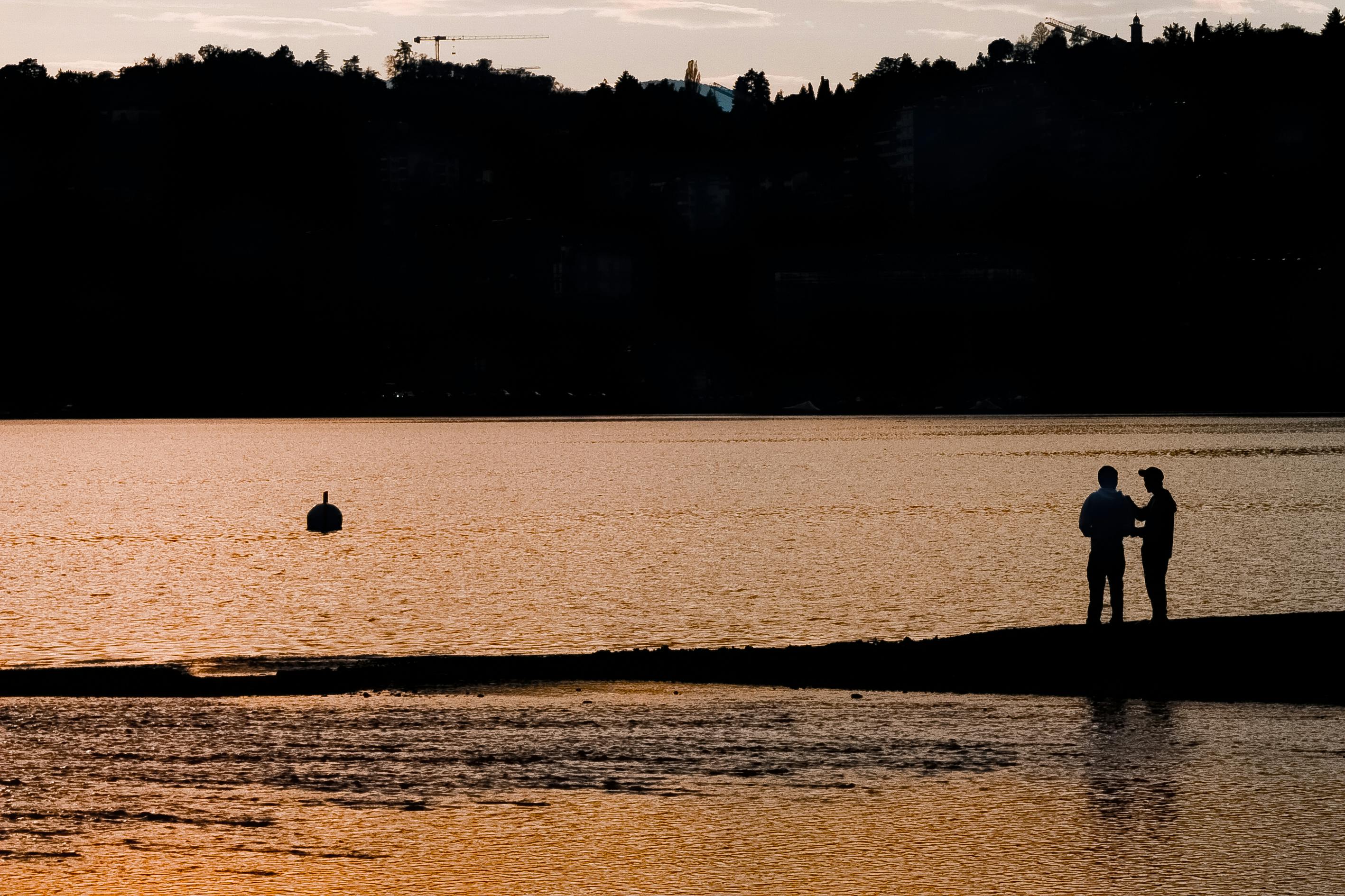 Two People Standing on the Beach during Sunset · Free Stock Photo