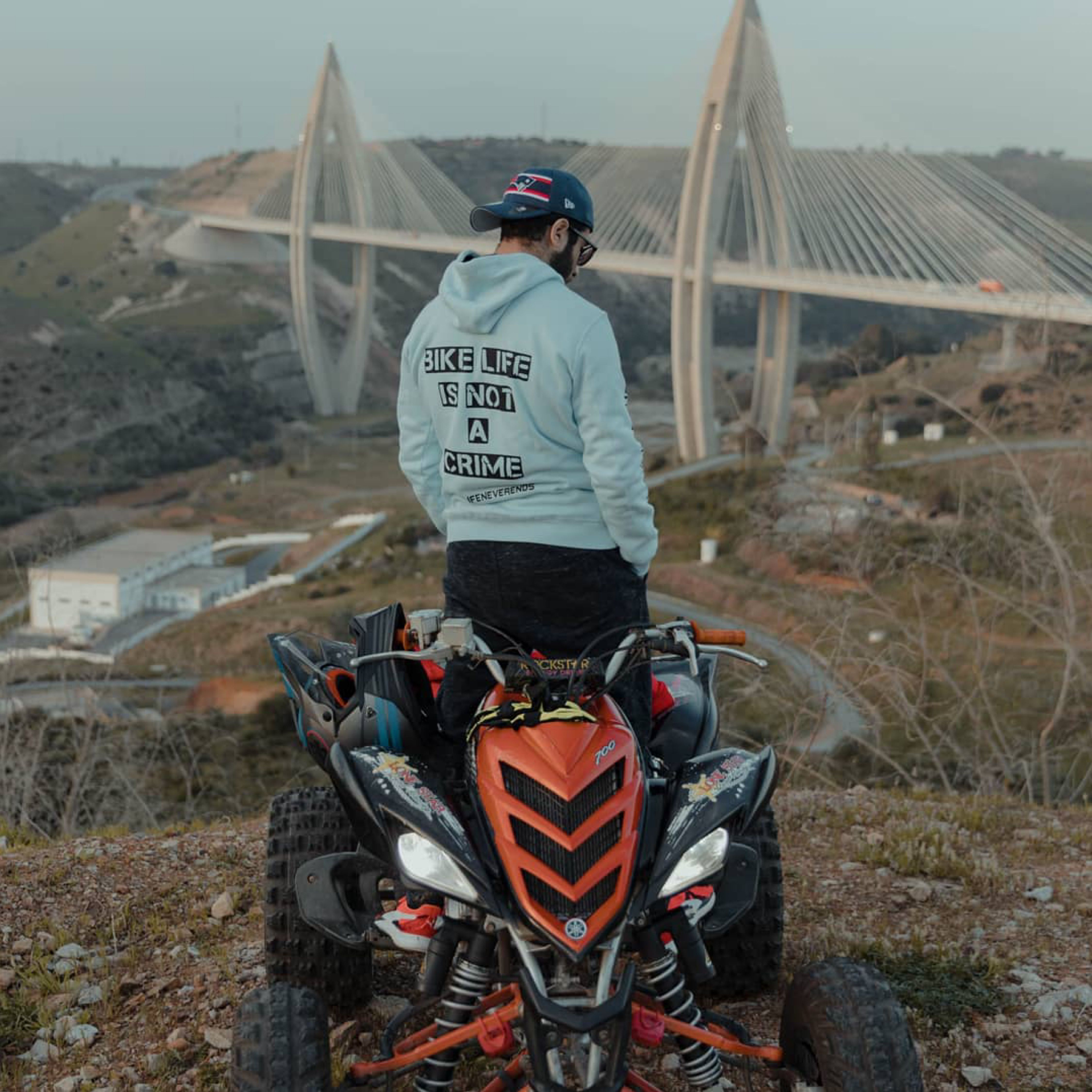 A Man Standing near the Atv Parked on the Field · Free Stock Photo