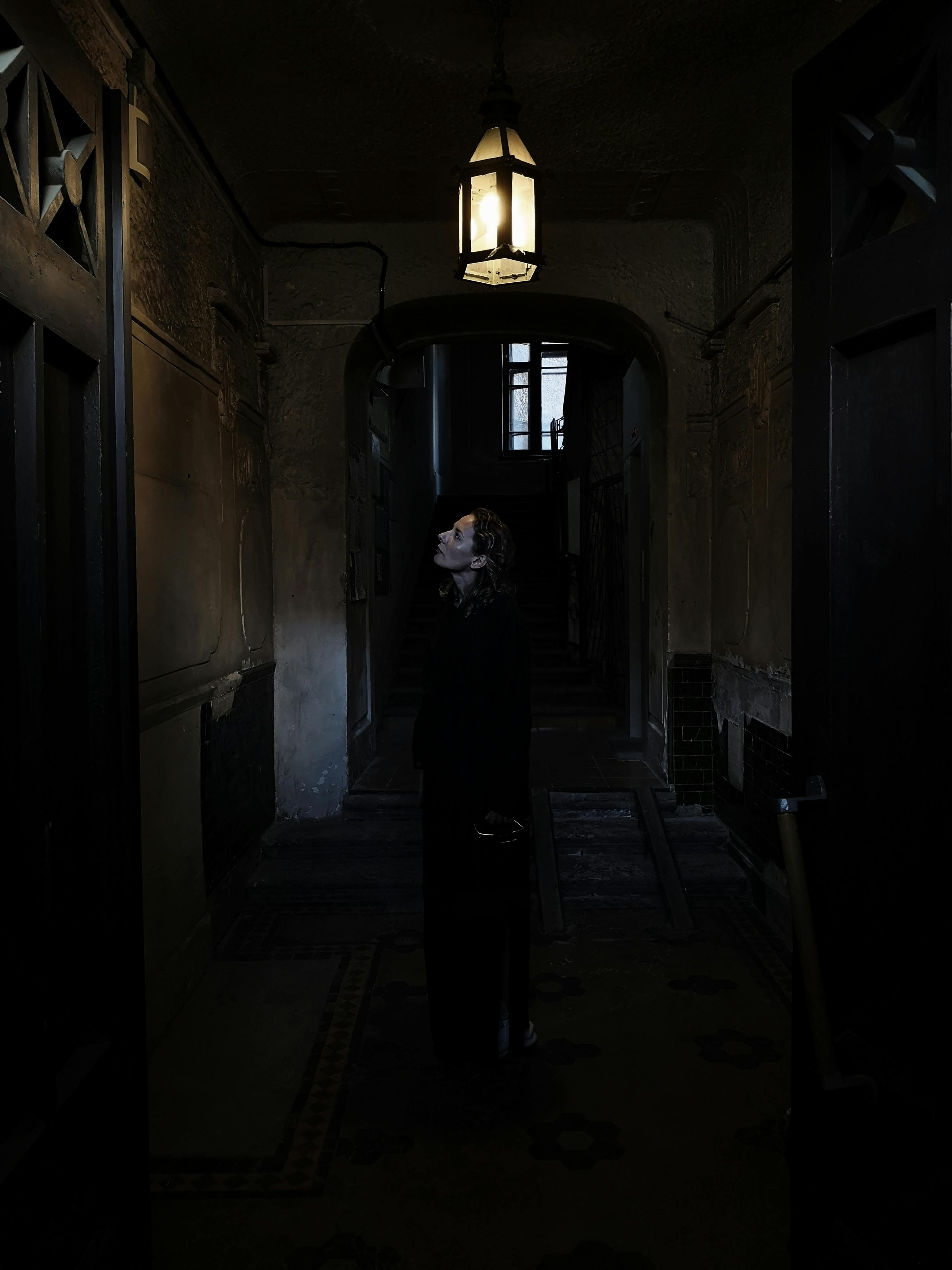 Person Standing in a Hallway in a Dark Room · Free Stock Photo