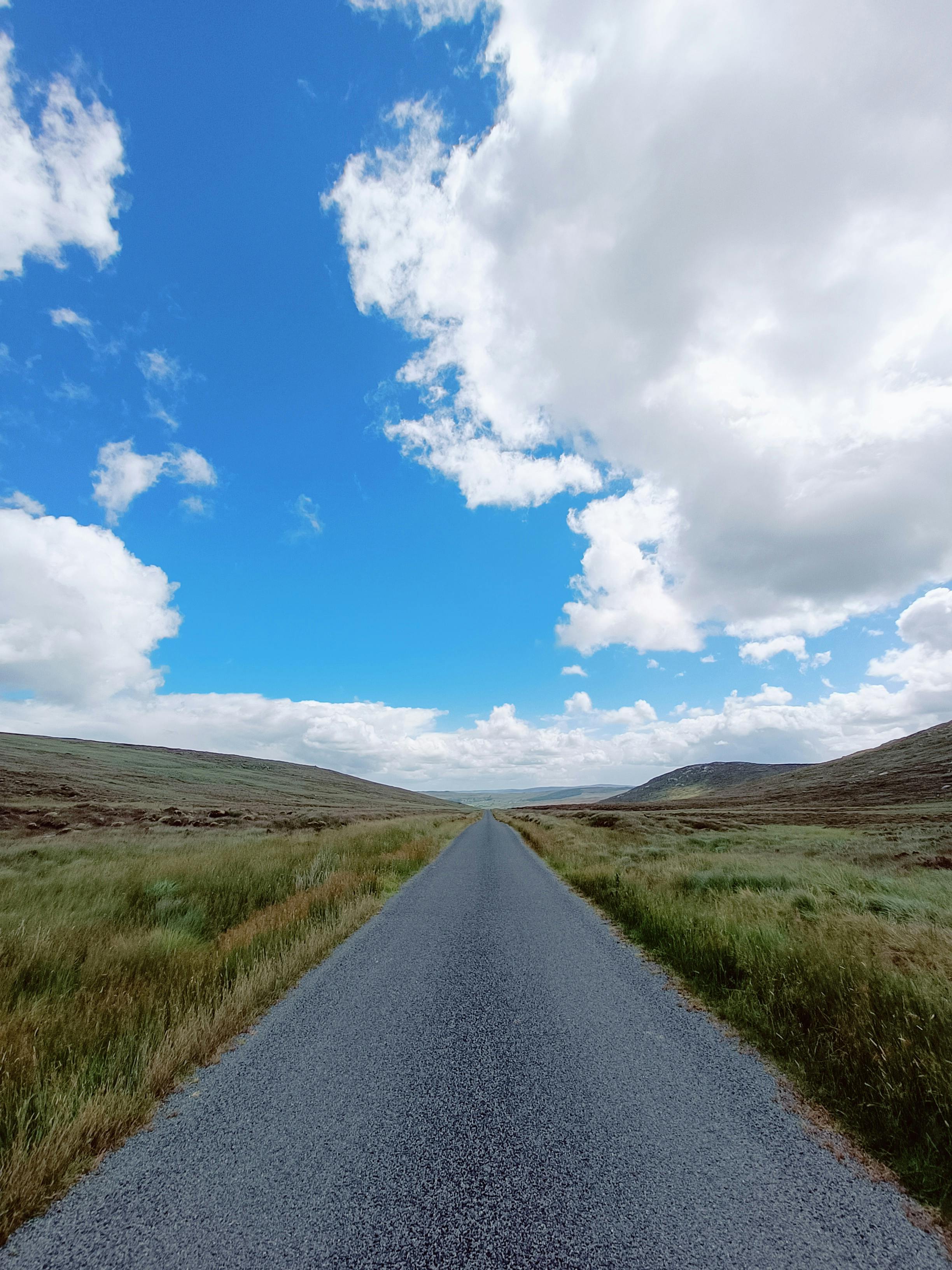 Paved Pathway Between Green Grass Under Blue Sky and White Clouds ...