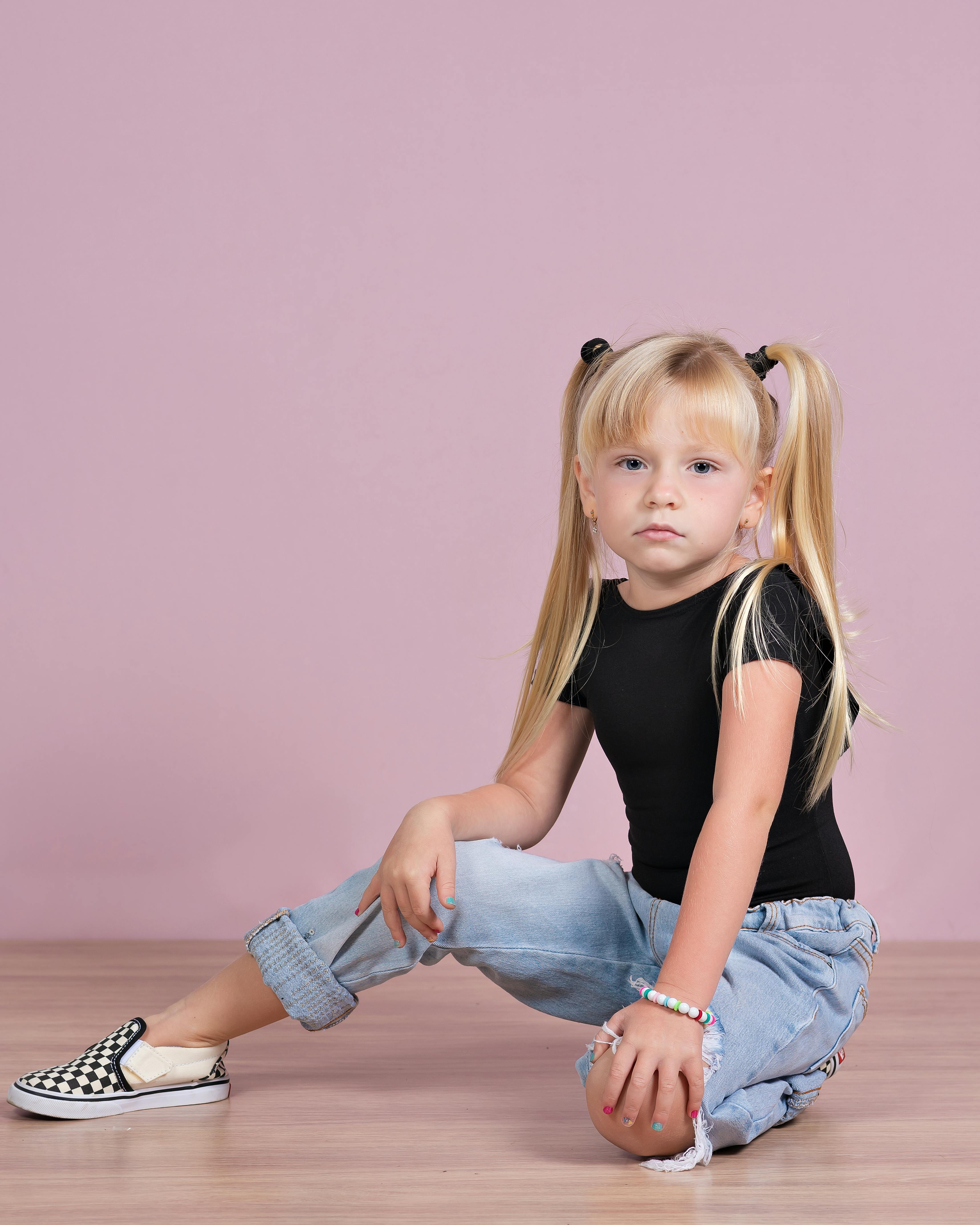 Crouching Woman Wearing Jeans and Orange Sweatshirt · Free Stock Photo