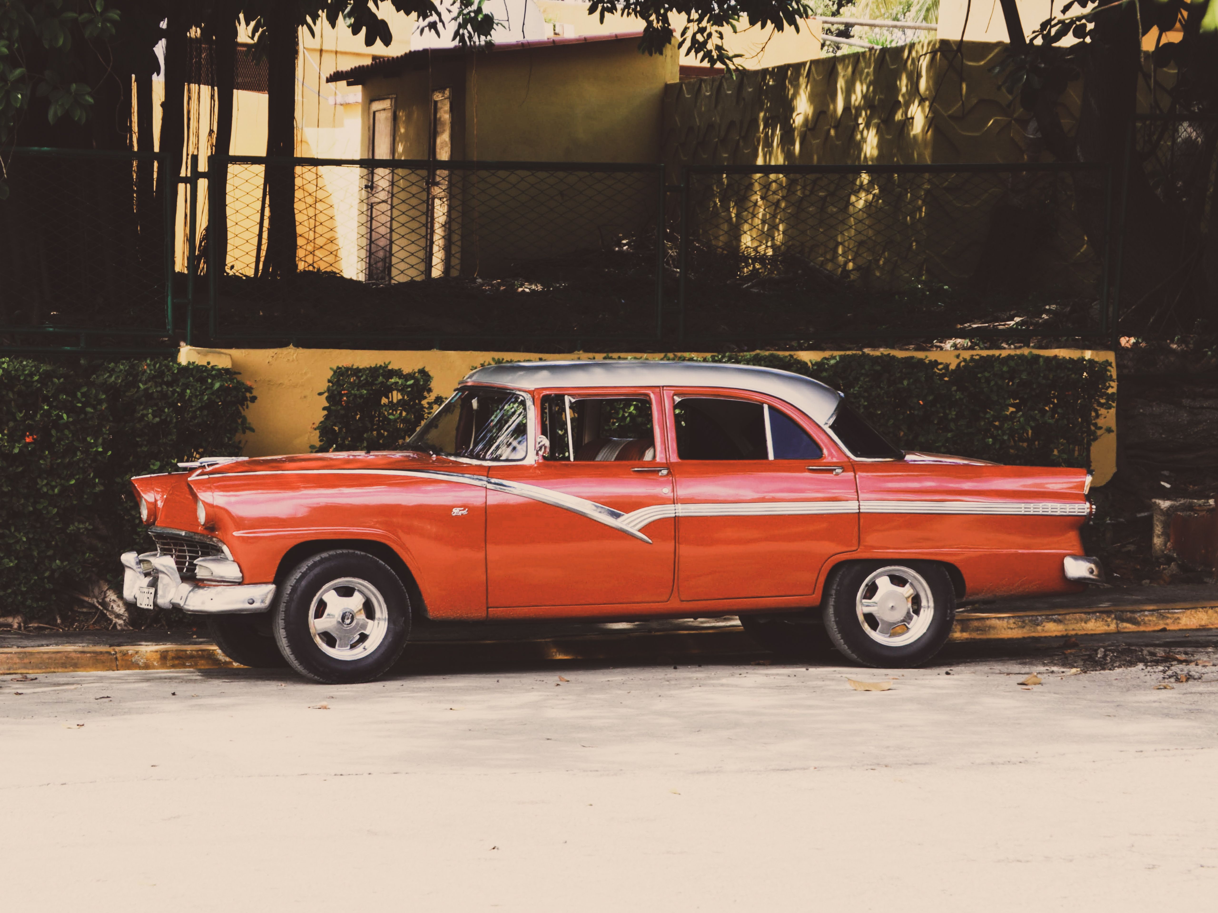 Red Sedan Parked Beside a Sidewalk · Free Stock Photo