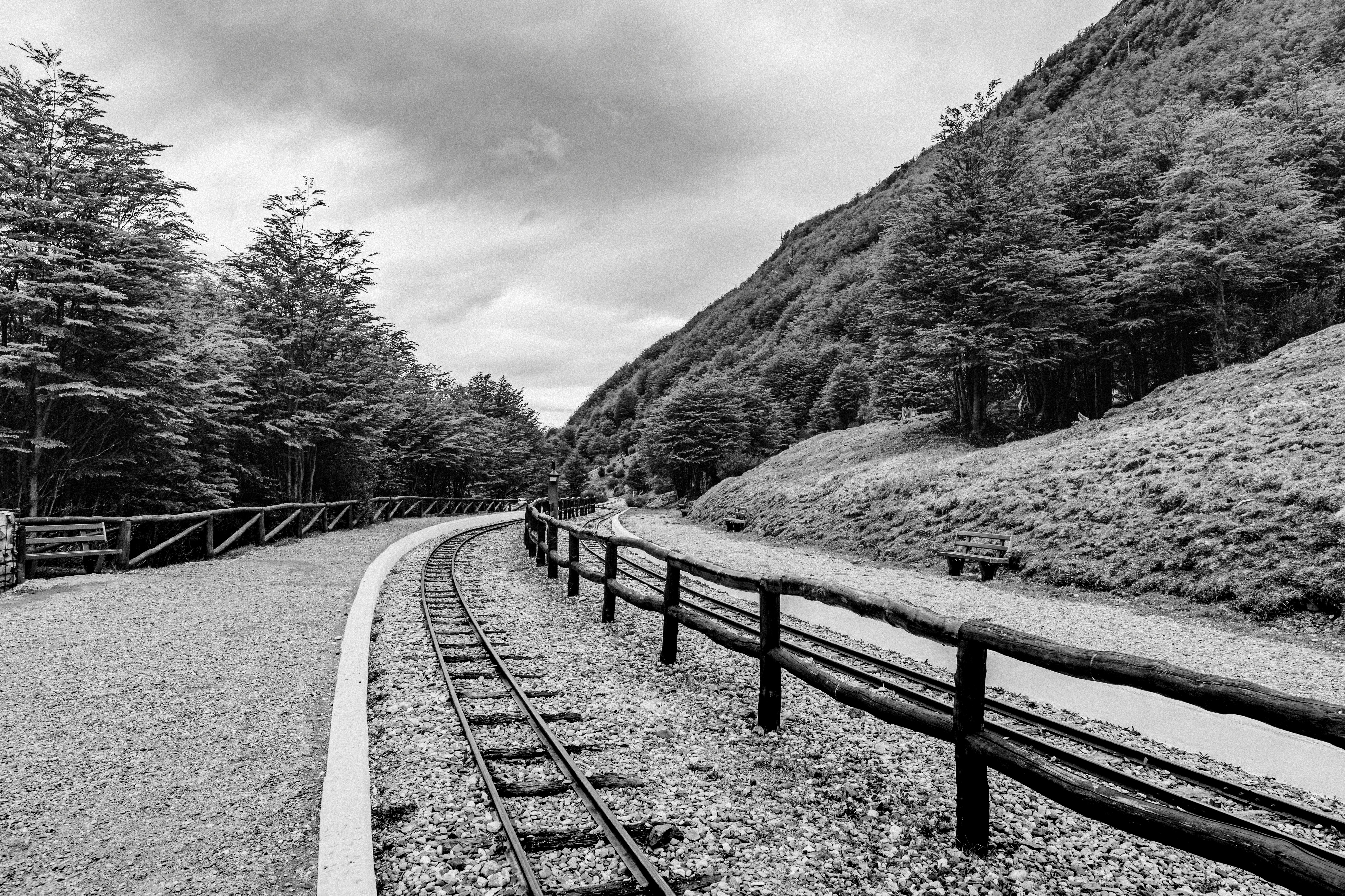 Grayscale Photo of Railway near Mountains · Free Stock Photo