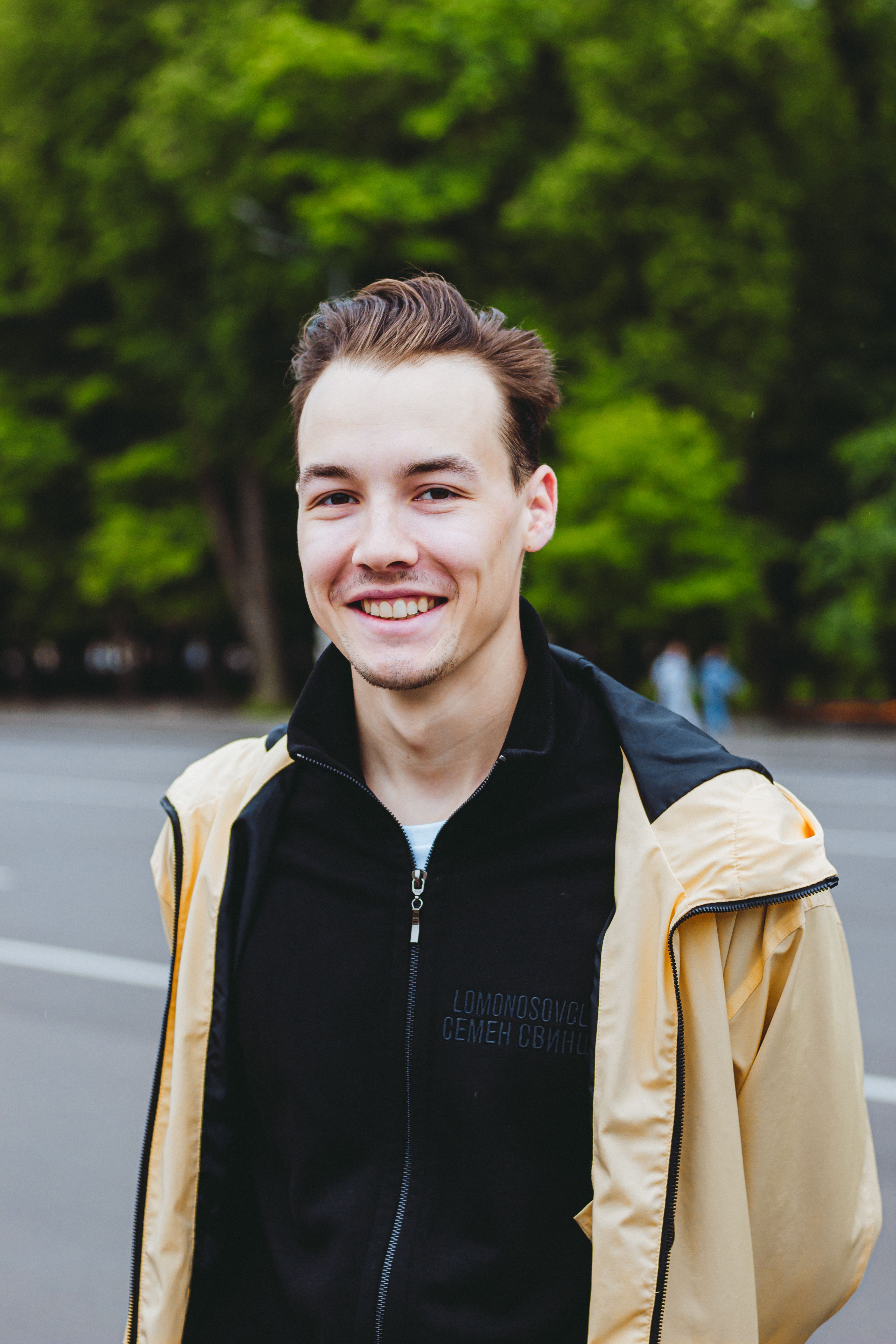 Young Man Smiling Outdoors in Green Nature · Free Stock Photo