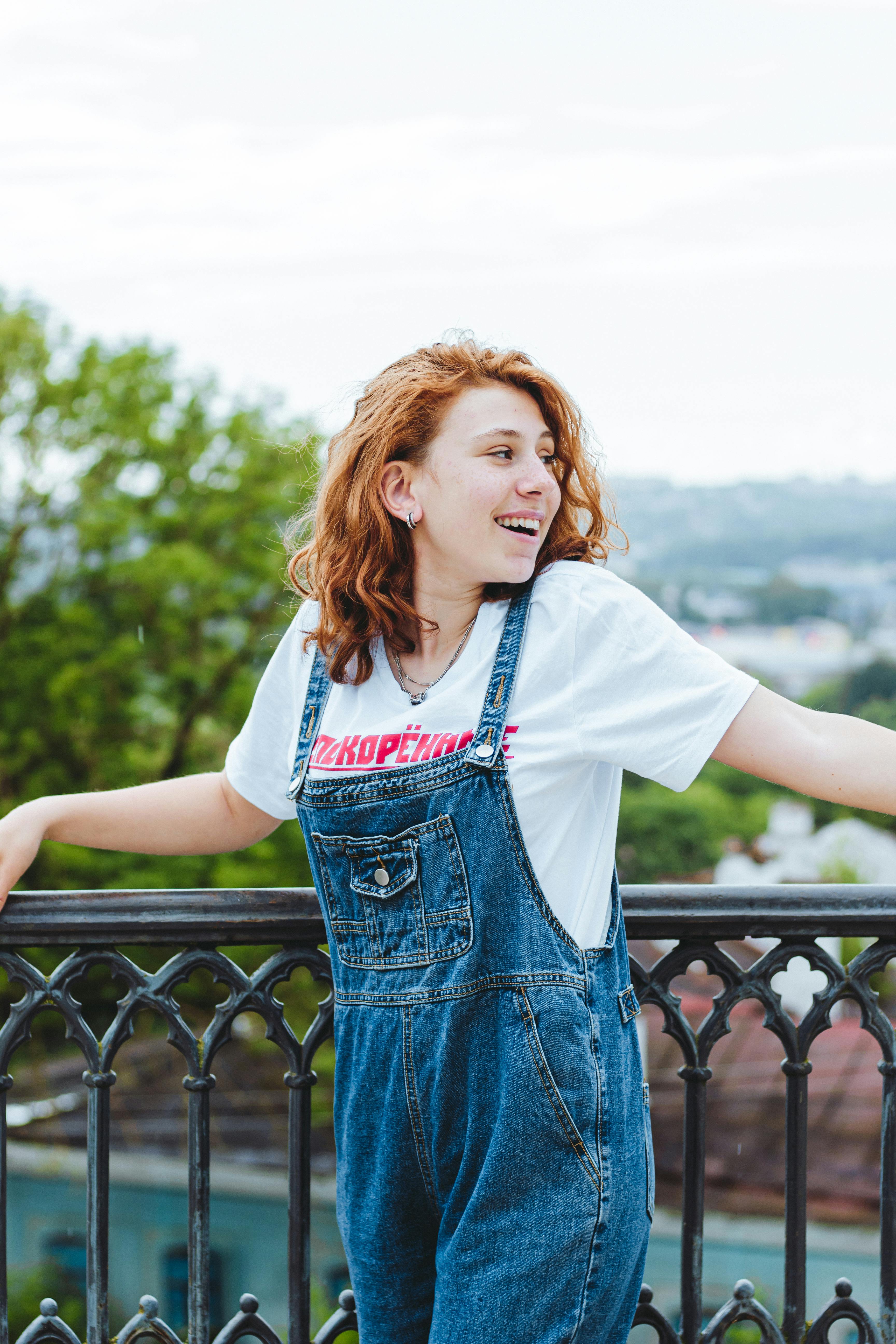 Woman in Denim Overalls Leaning on Tree Trunk · Free Stock Photo