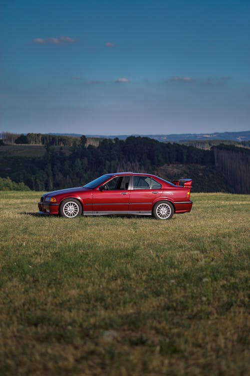 Red Car Parked on Green Grass Field · Free Stock Photo Red Car Parked on Green Grass Field · Free Stock Photo
