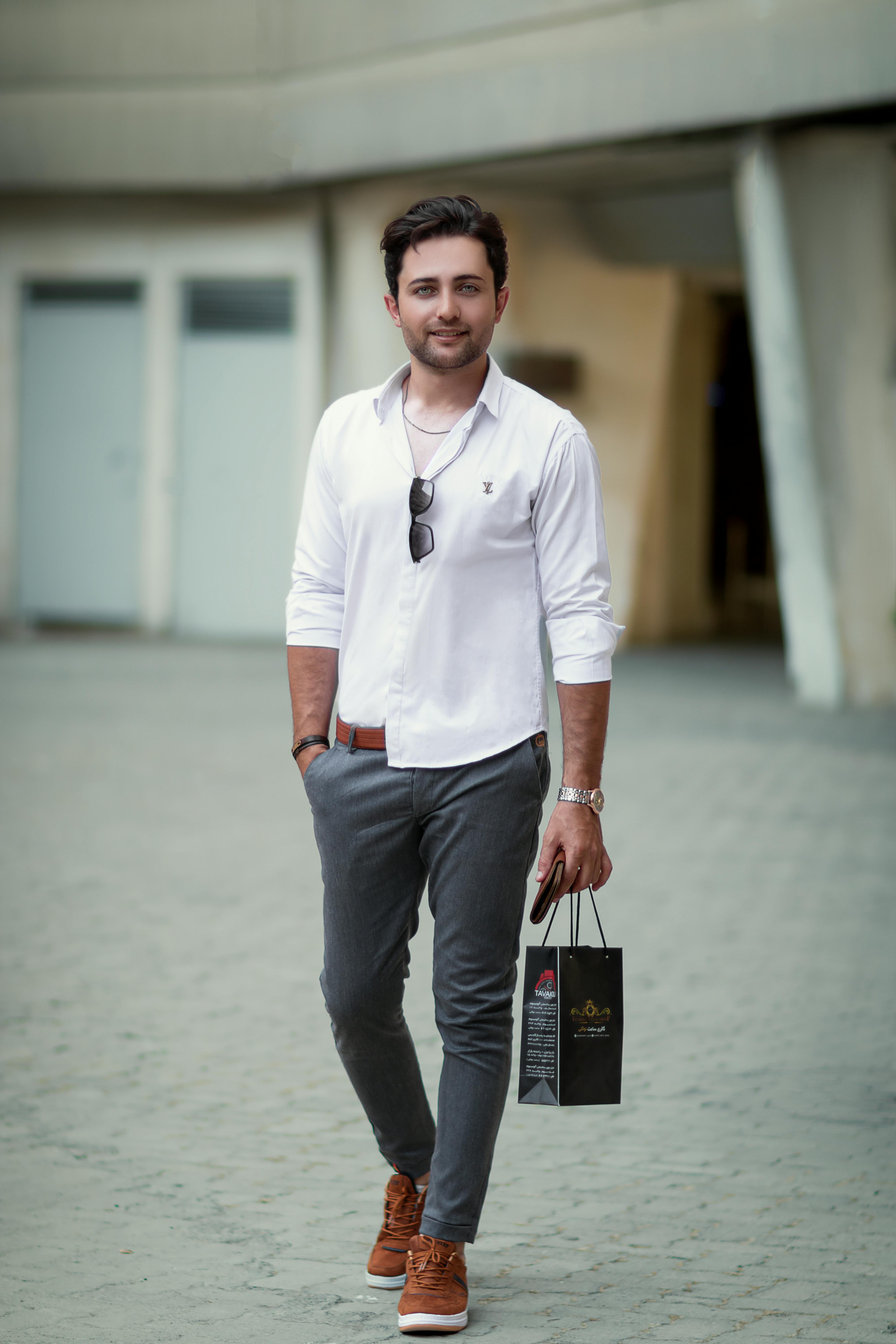 Photo of a Man Walking with a Black Paper Bag · Free Stock Photo