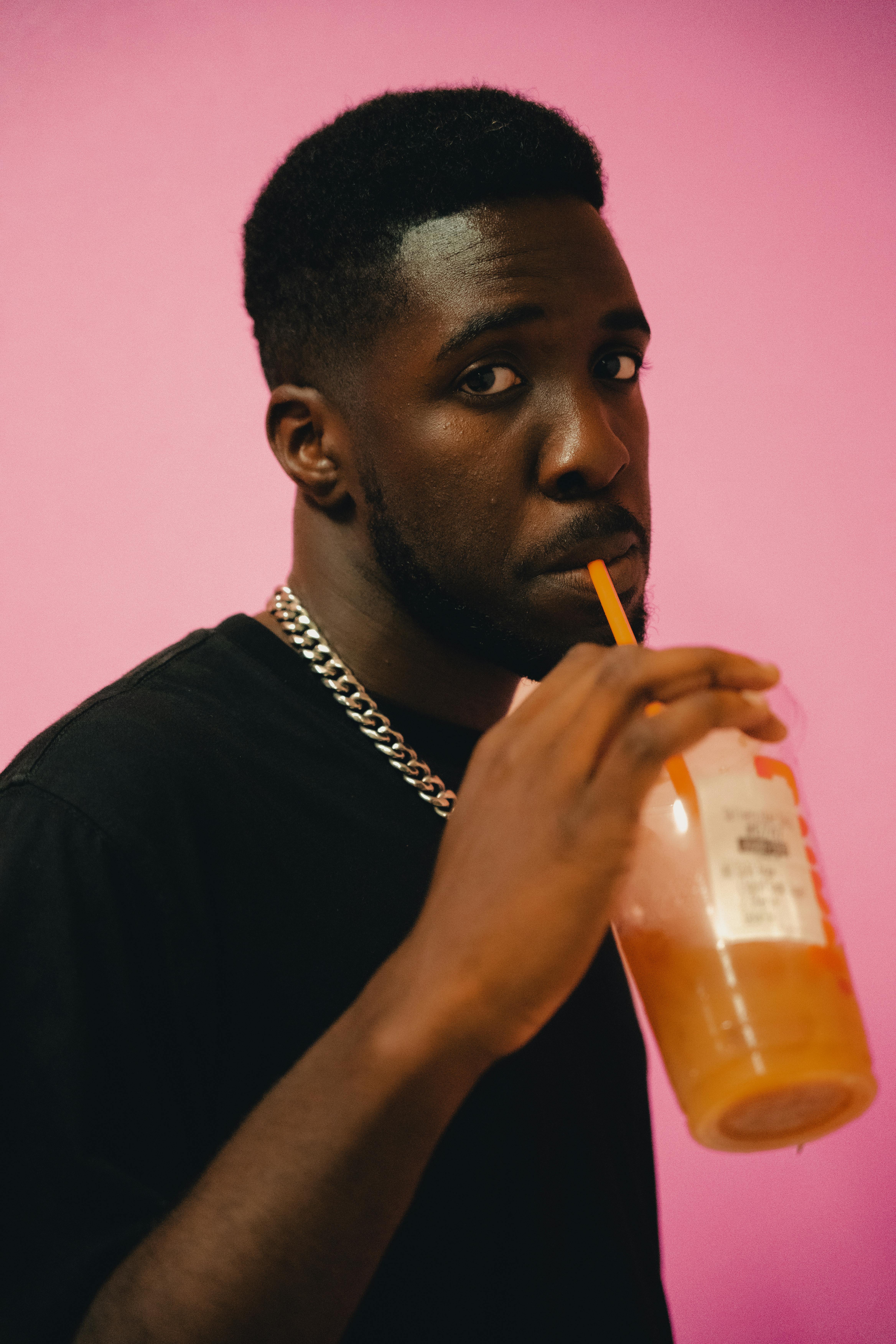 Man Drinking Juice on Pink Studio Background · Free Stock Photo