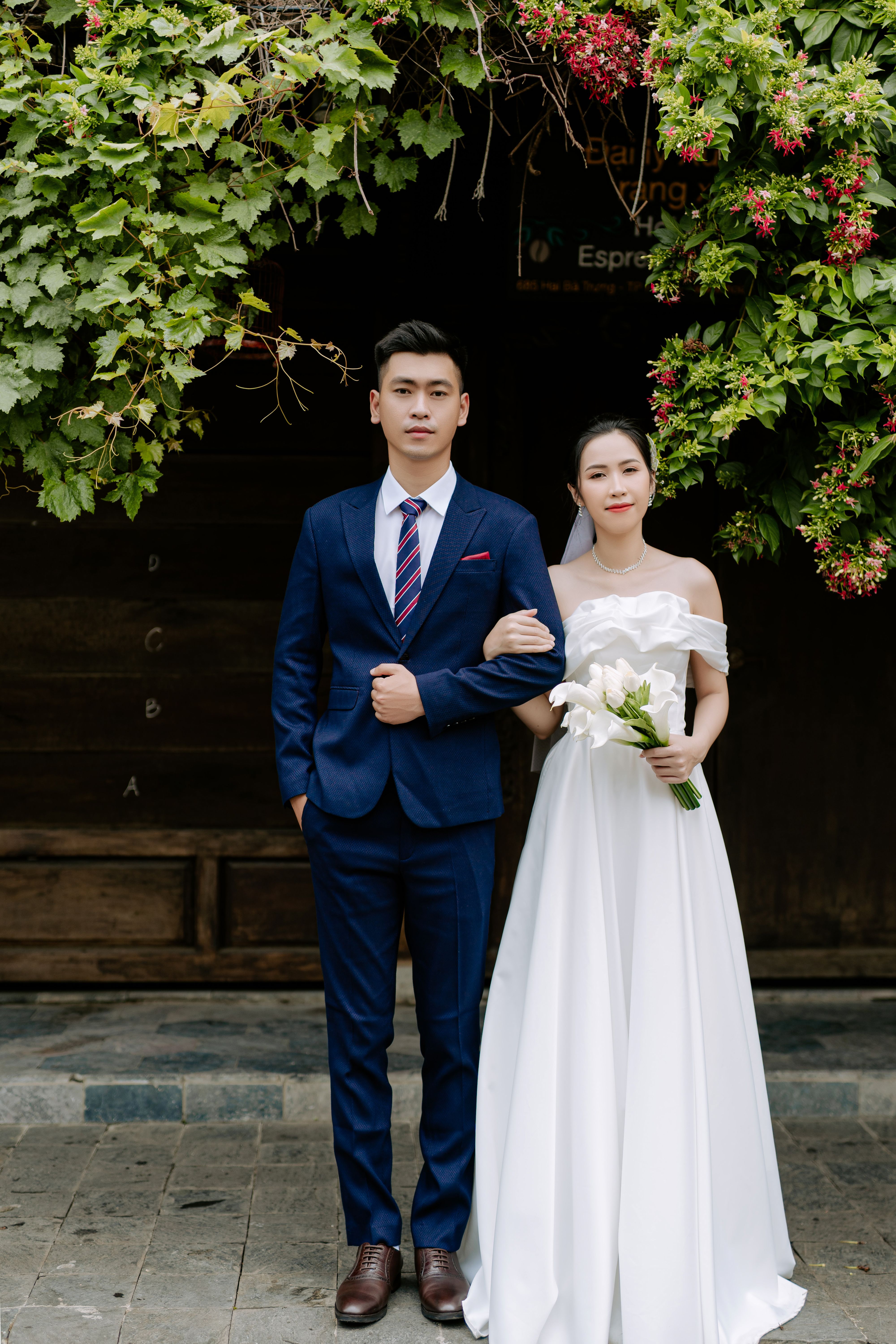 Bride in Long White Gown and Groom in Elegant Suit Posing by Window ...