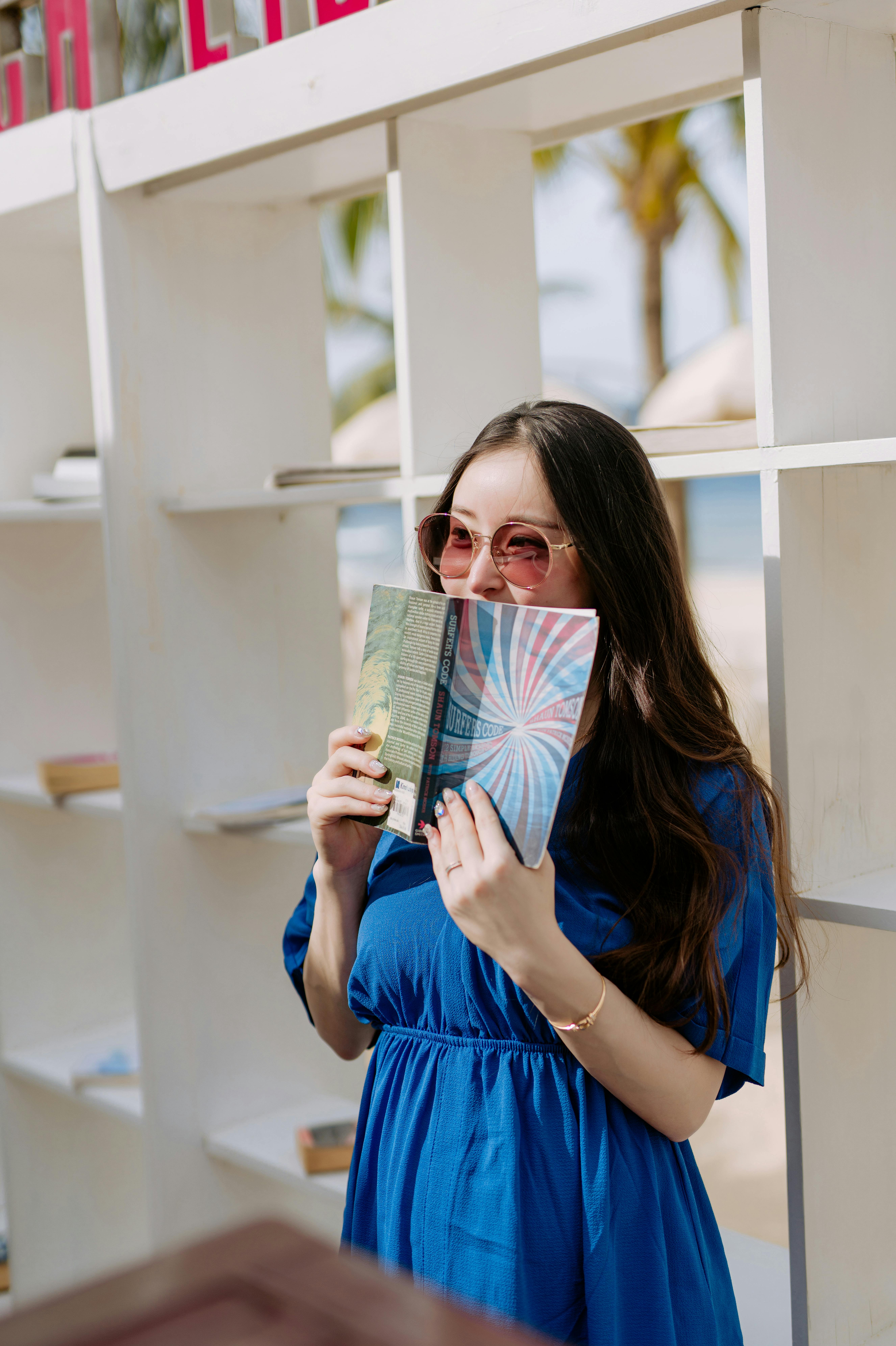 Woman in Blue Dress Holding a Book · Free Stock Photo