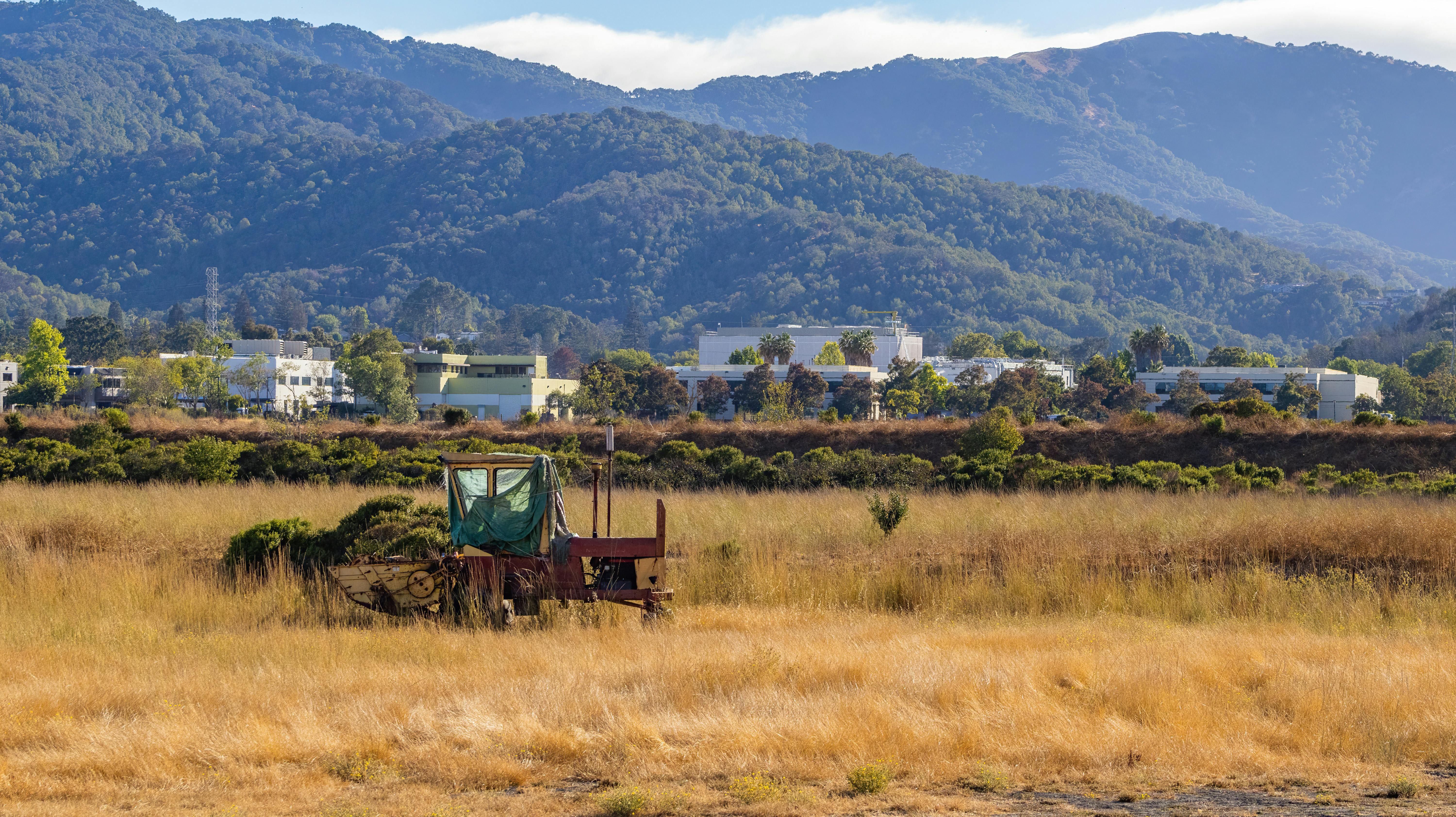 Tractor on a Field in a Mountain Valley · Free Stock Photo