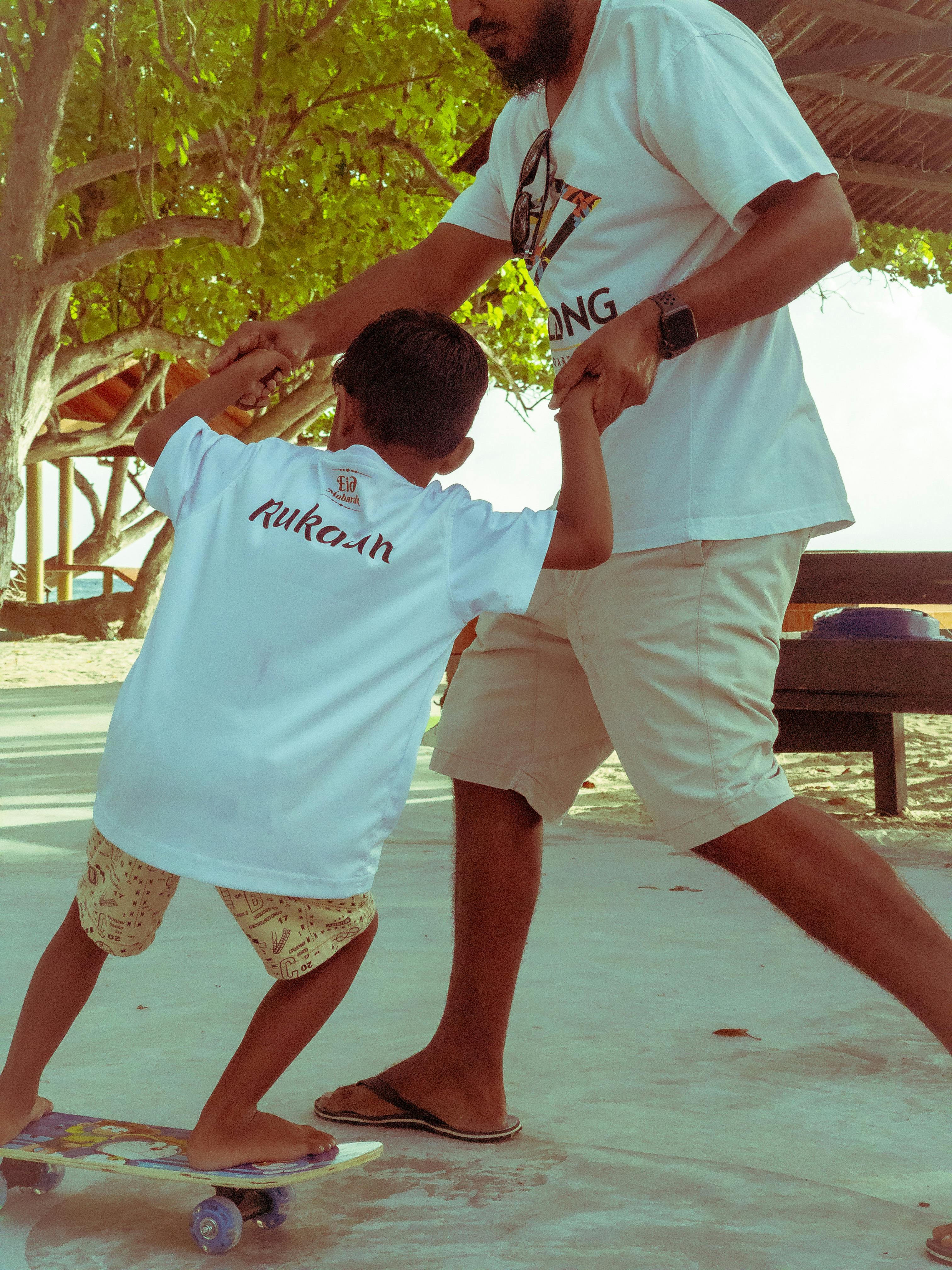 Photo of Man Teaching a Boy Skateboarding · Free Stock Photo