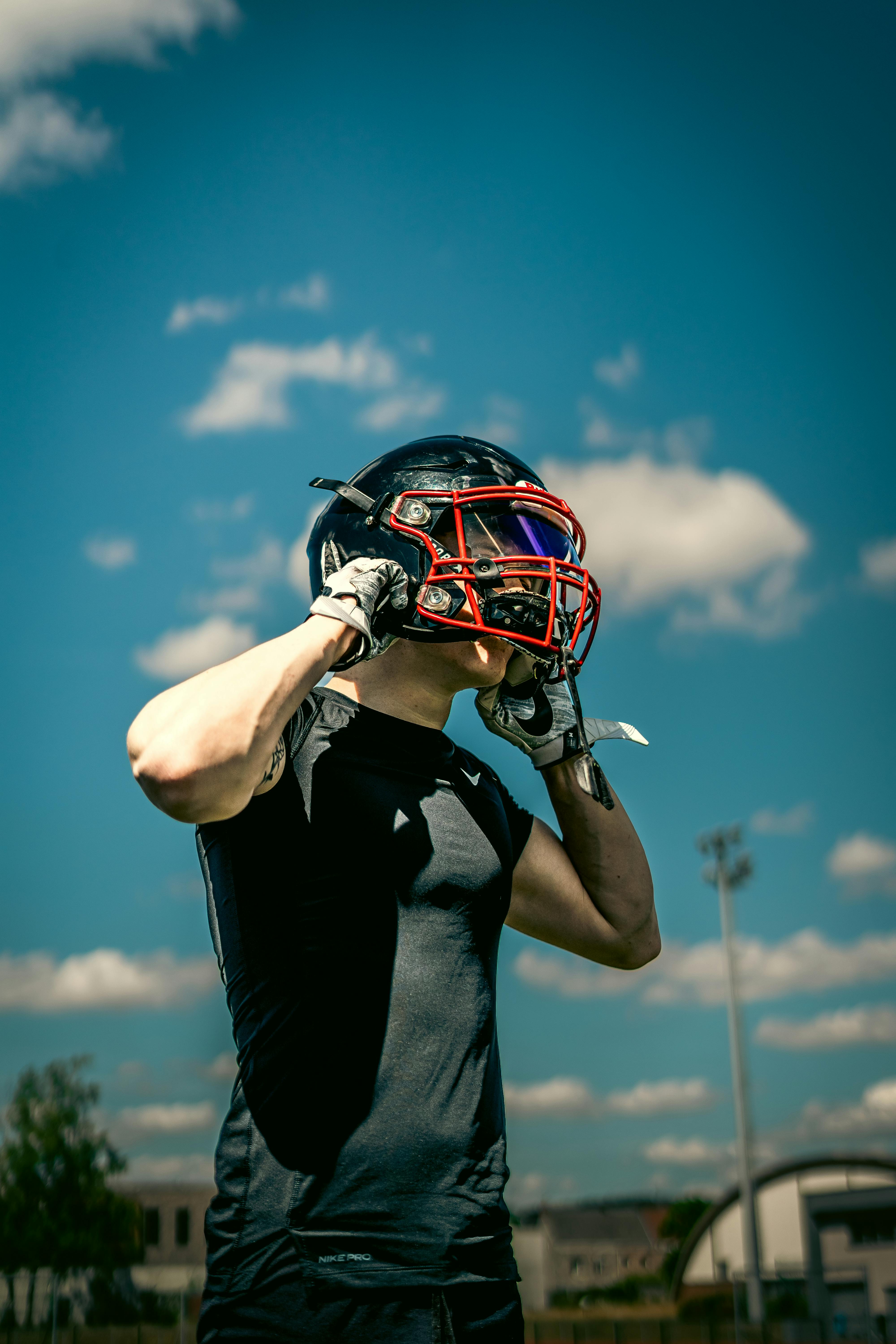 A Football Player Taking Off a Helmet · Free Stock Photo