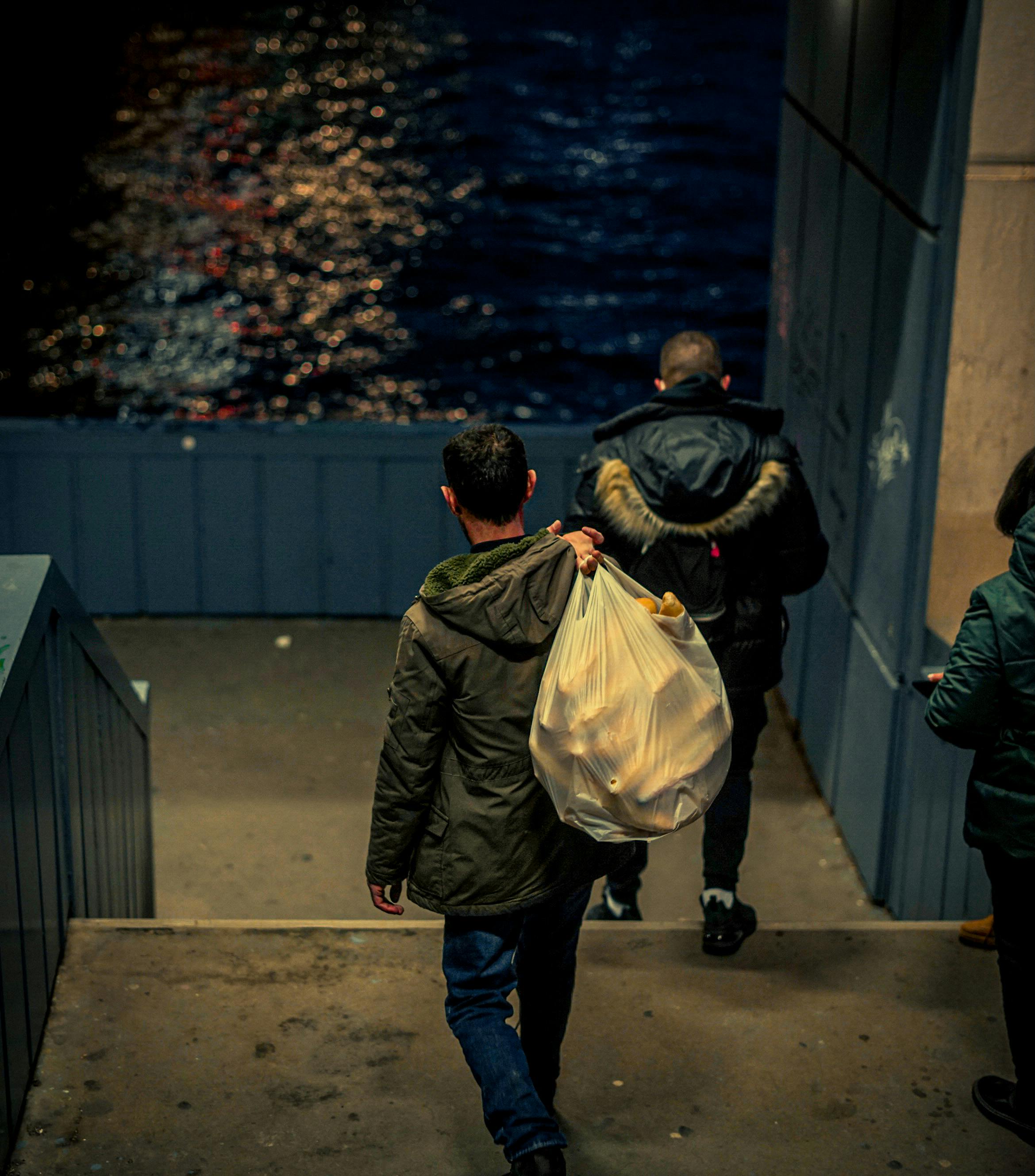 Back View of a Man Carrying a Plastic Bag · Free Stock Photo