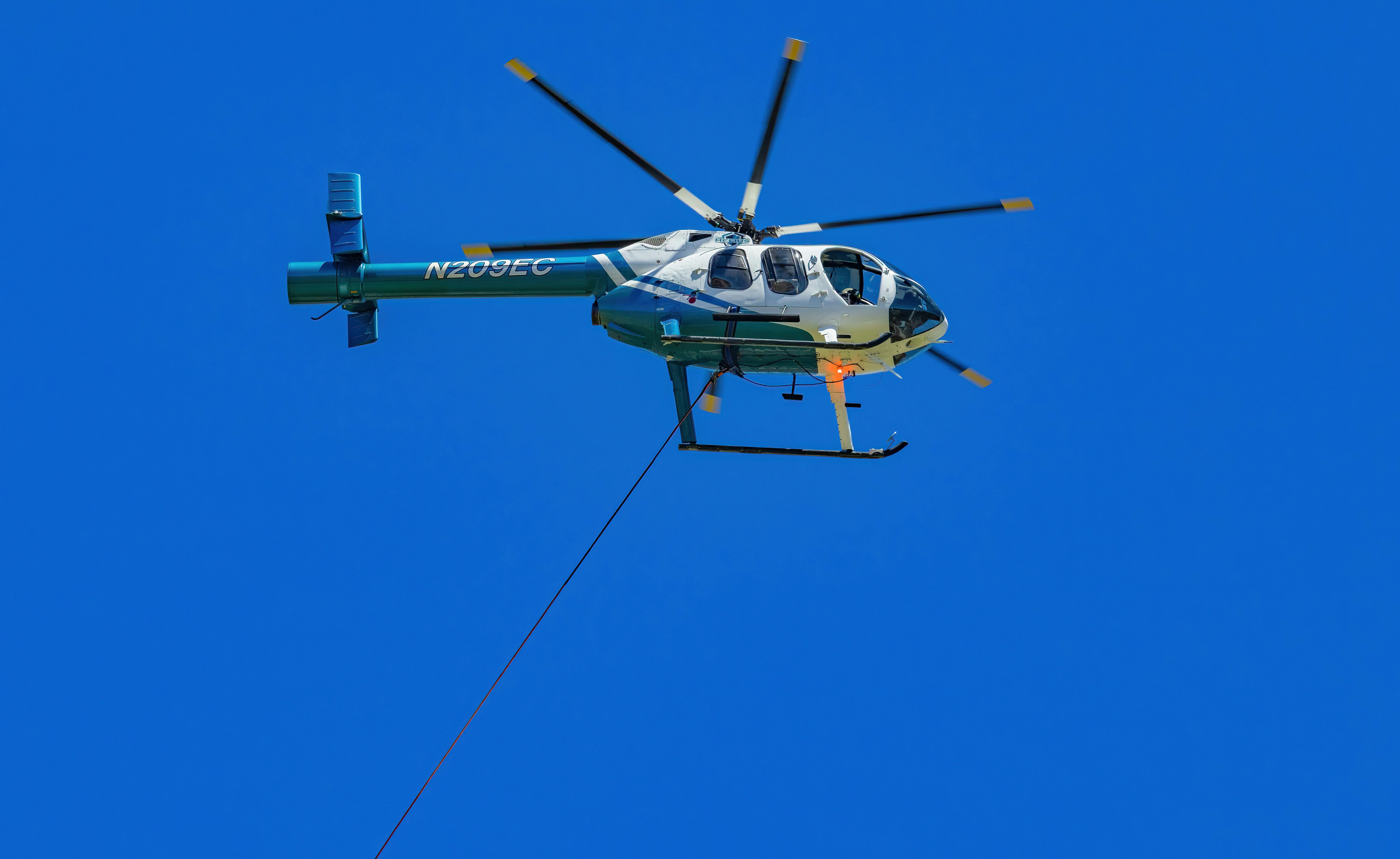 A Blue and White Helicopter Flying in the Sky · Free Stock Photo