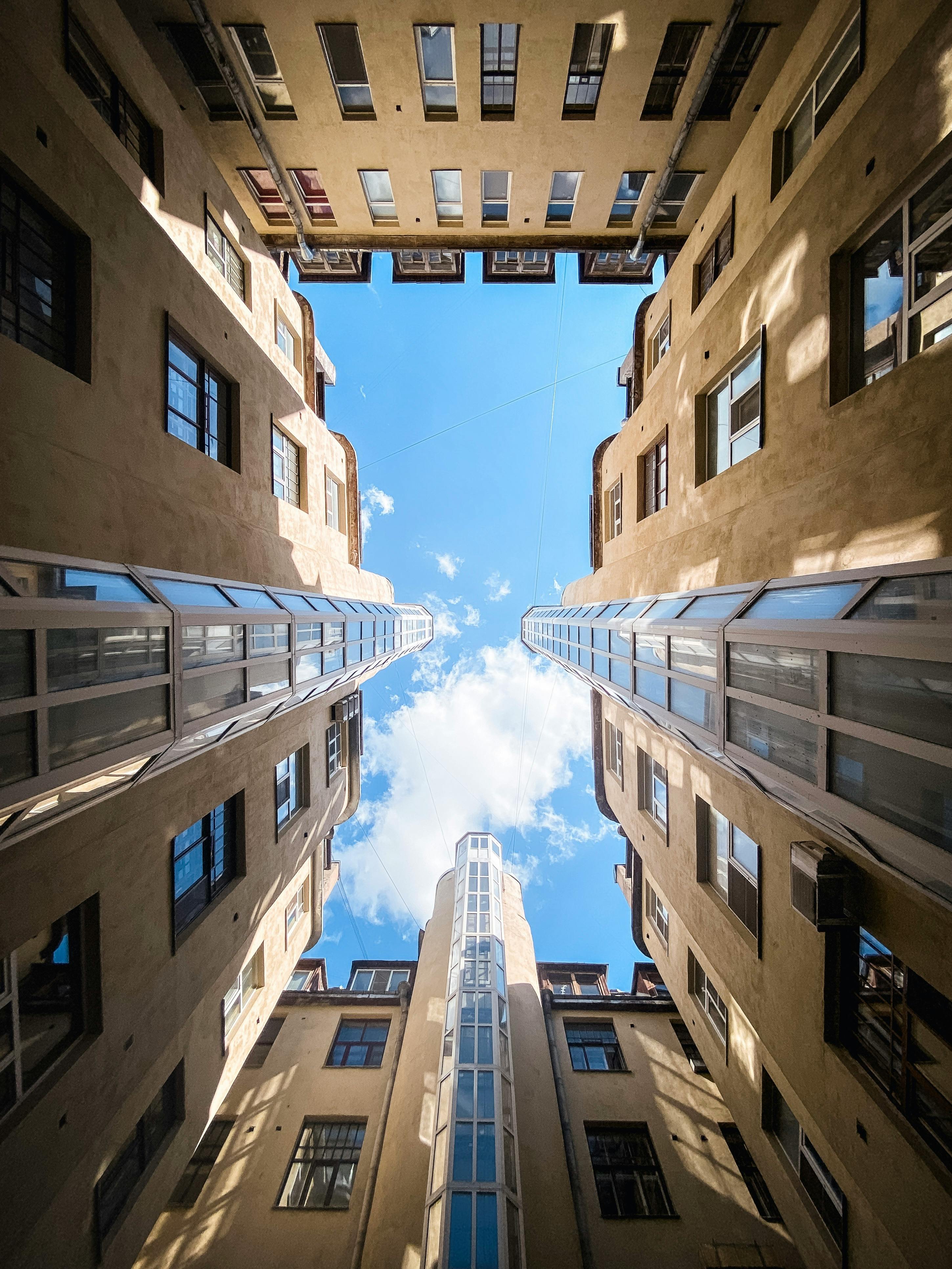 Low Angle View of Blue Sky in Space between Buildings · Free Stock Photo