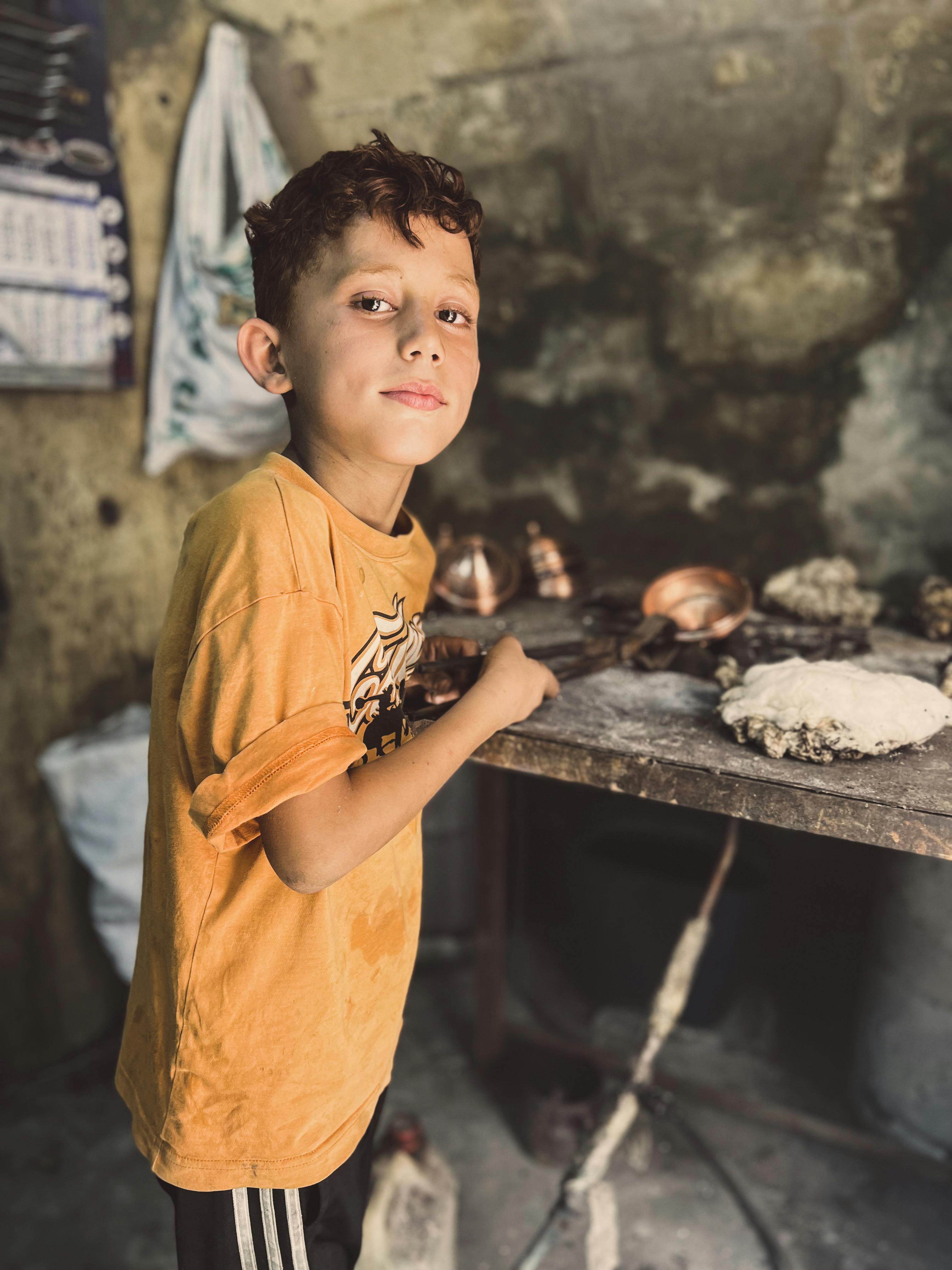Boy Playing in a Blacksmith Studio · Free Stock Photo