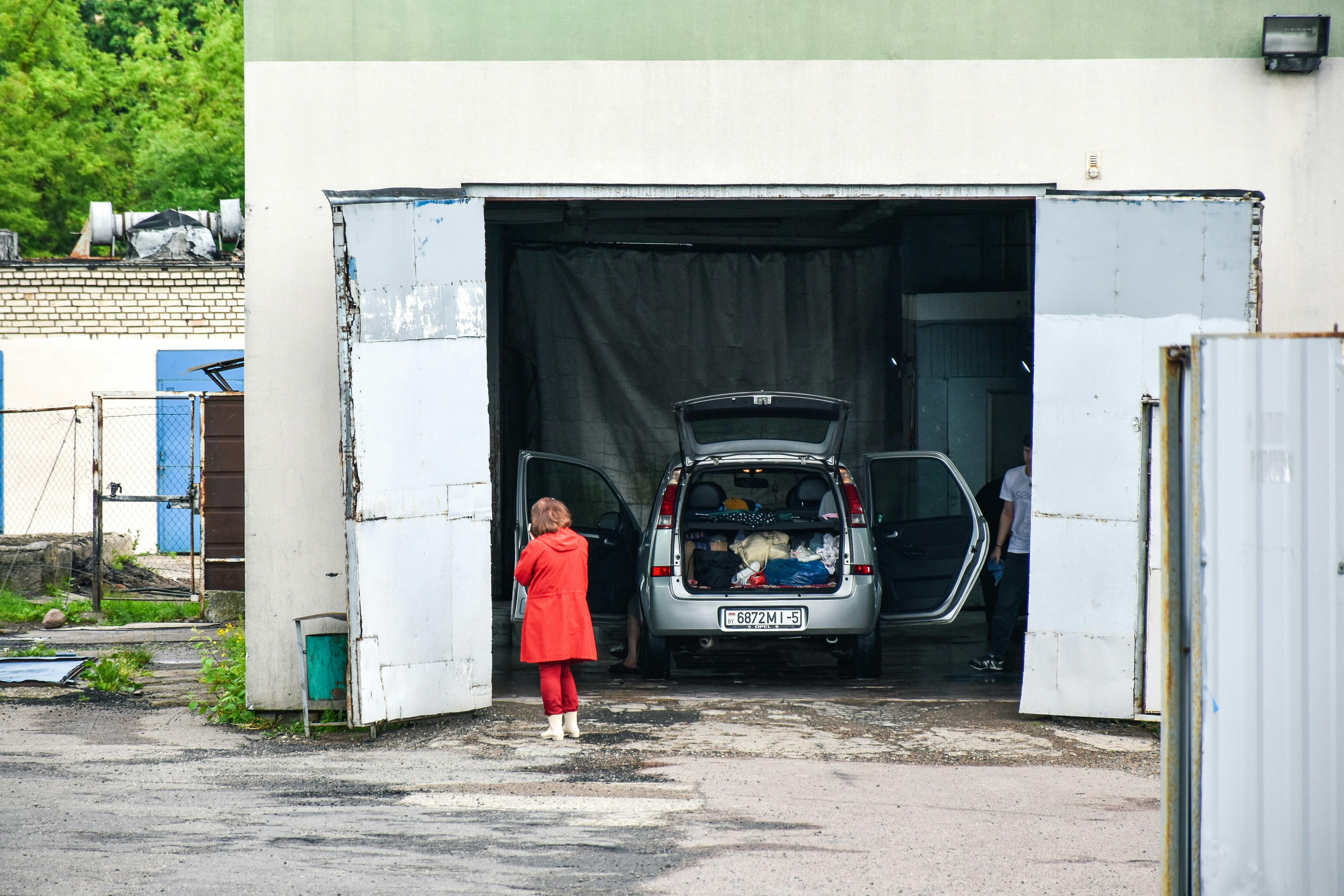 Male in face mask taking things out of car trunk · Free Stock Photo