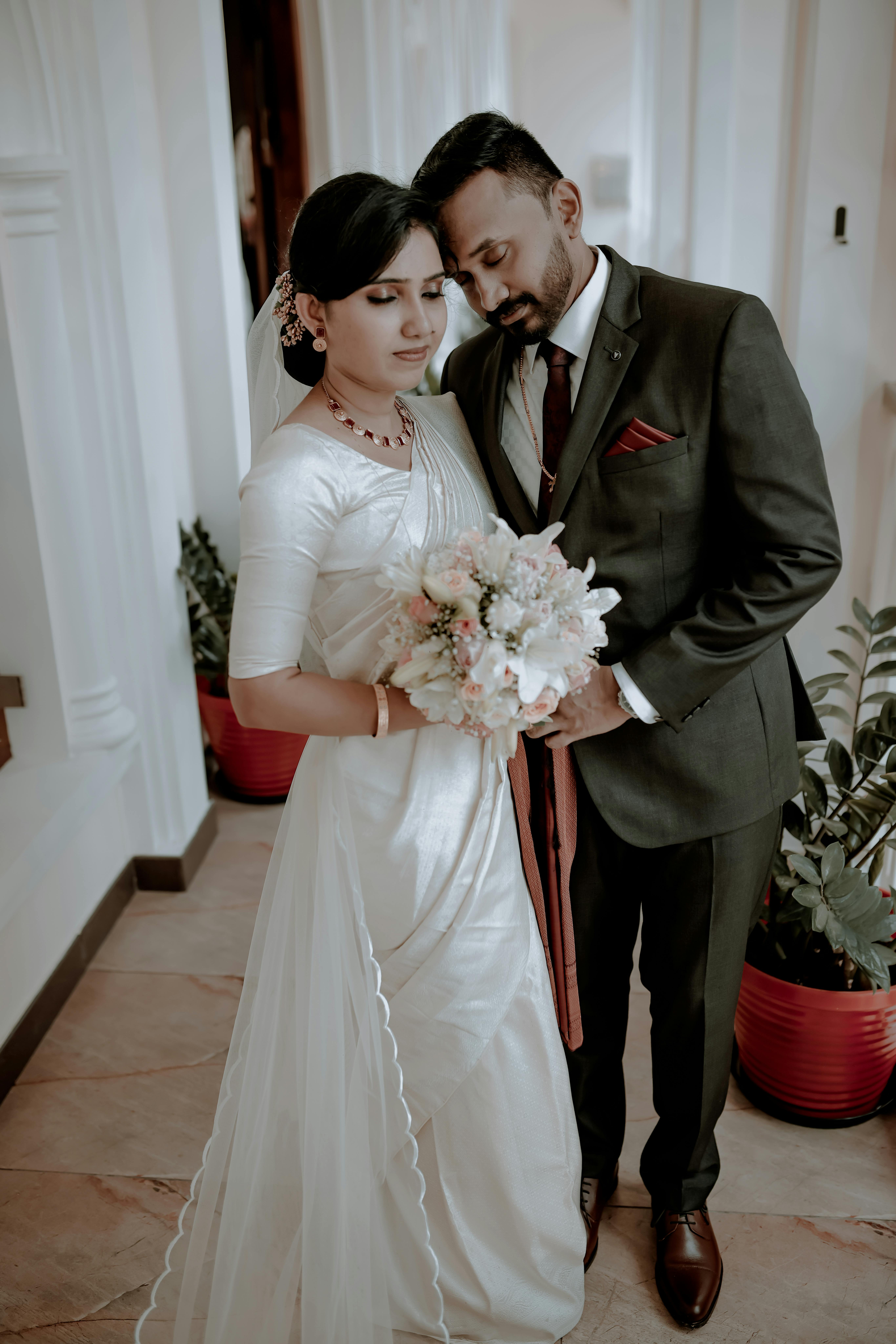 Man in Black Suit Kissing Woman in White Wedding Dress Facing Each ...
