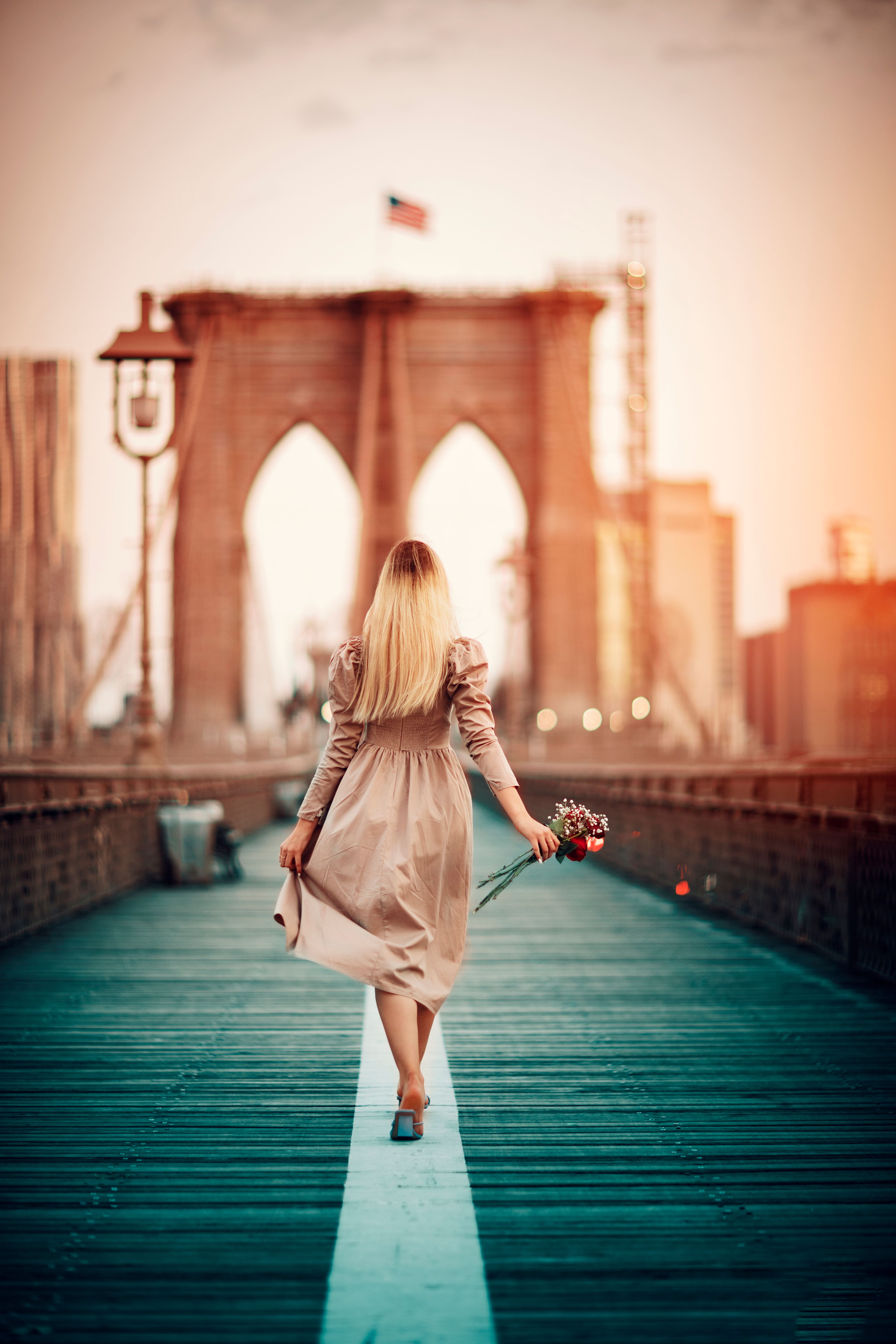 Woman Walking down a Bridge with Flowers in her Hand · Free Stock Photo