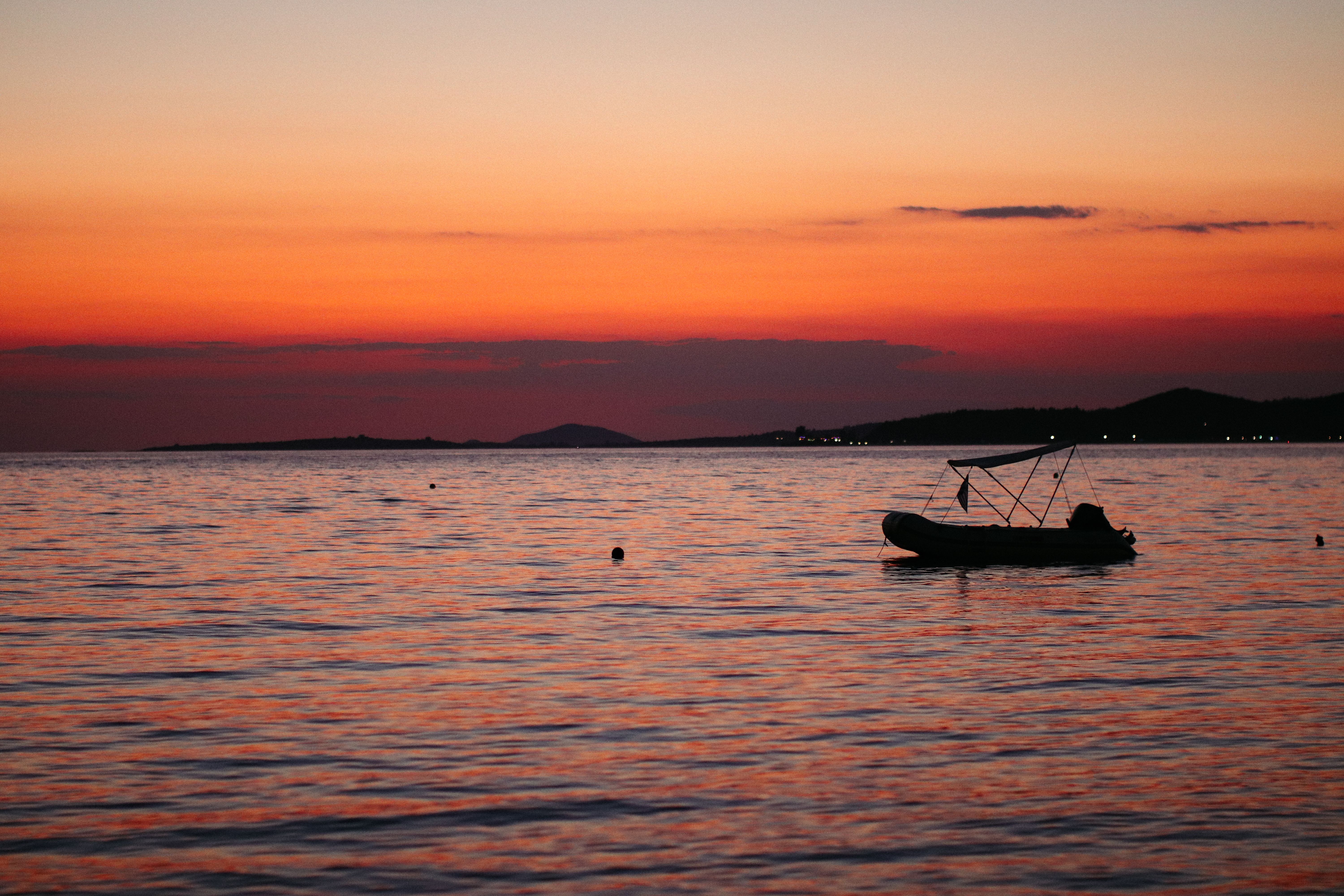 A Boat on a Sea During Sunset · Free Stock Photo