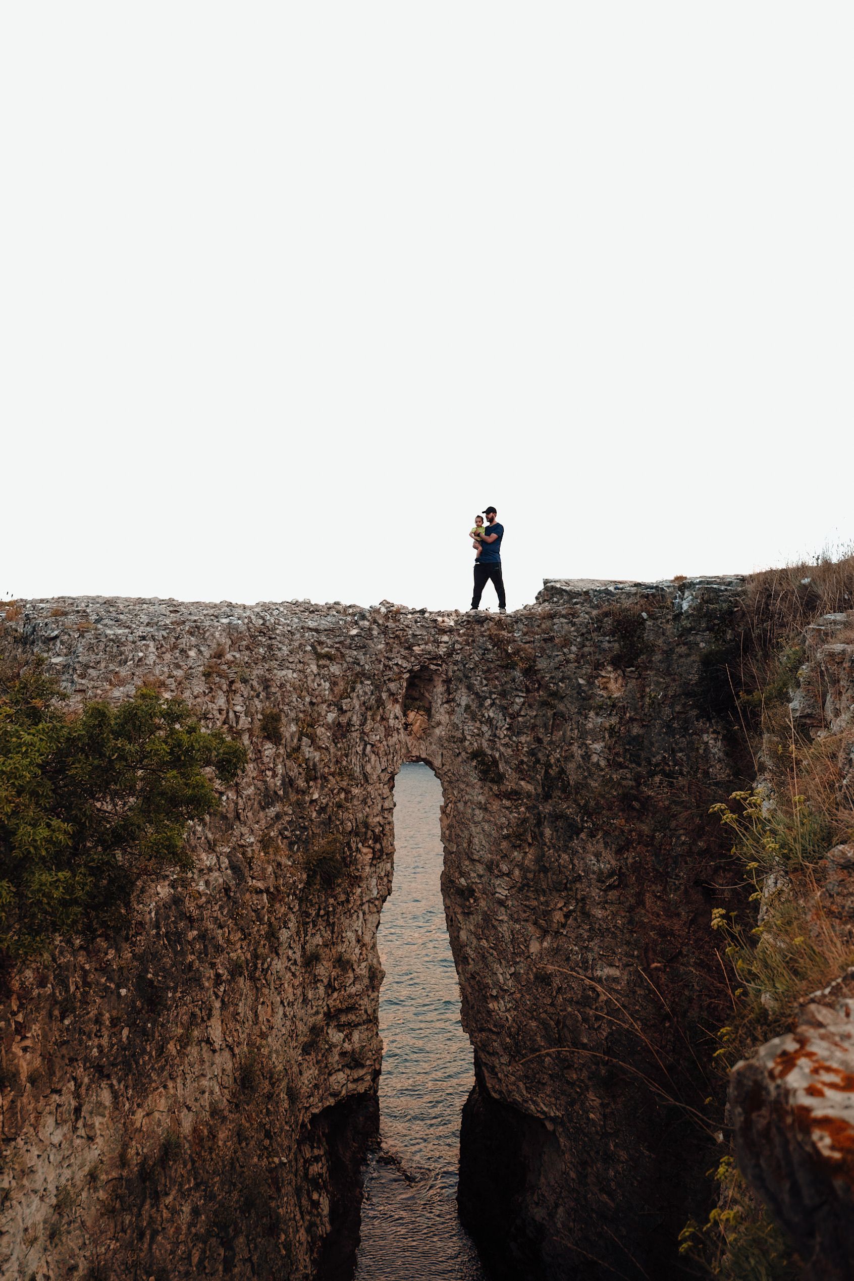 Man Holding a Baby on a Cliff · Free Stock Photo
