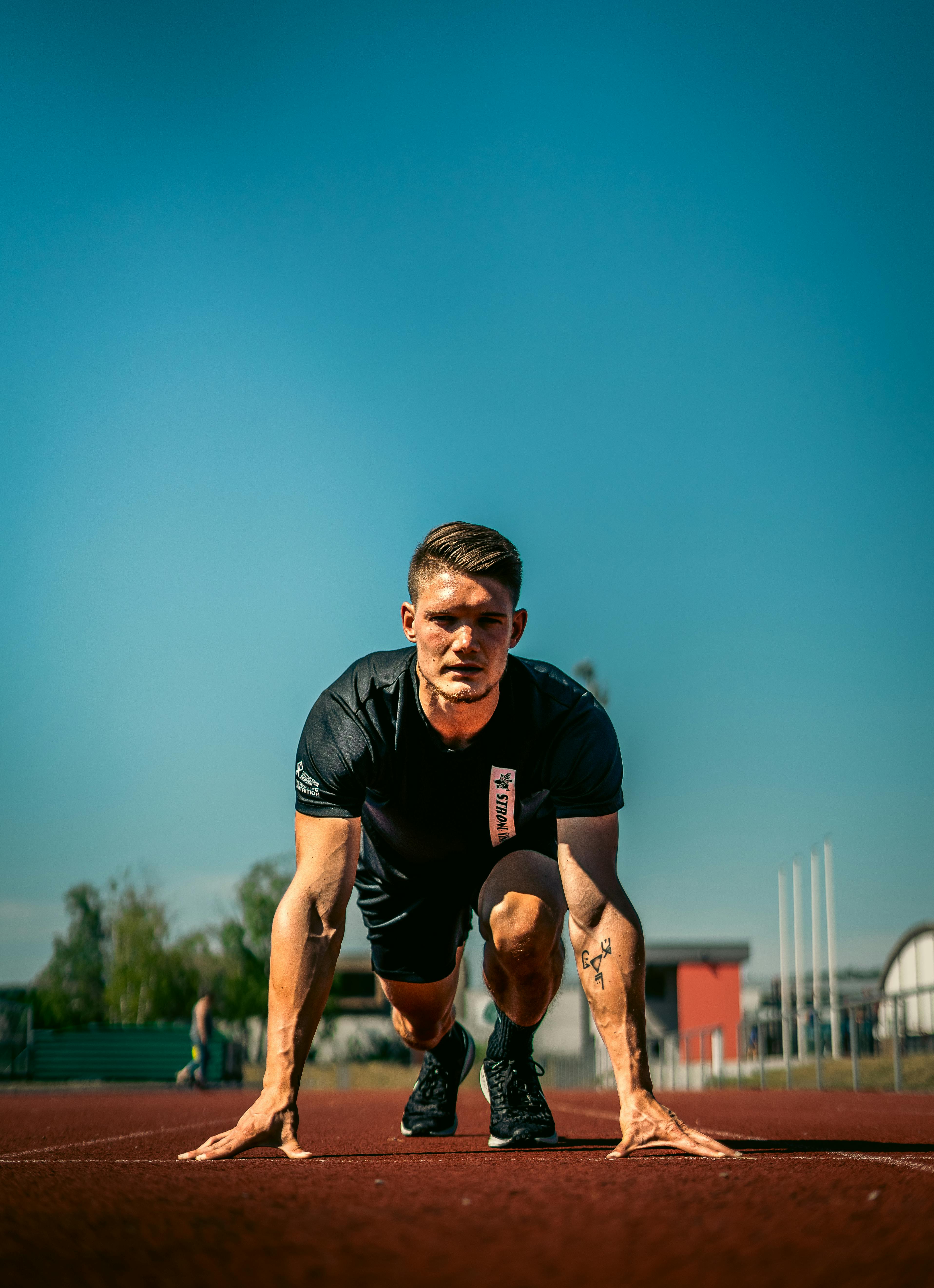 A Man in Black Shirt and Shorts Preparing to Run · Free Stock Photo