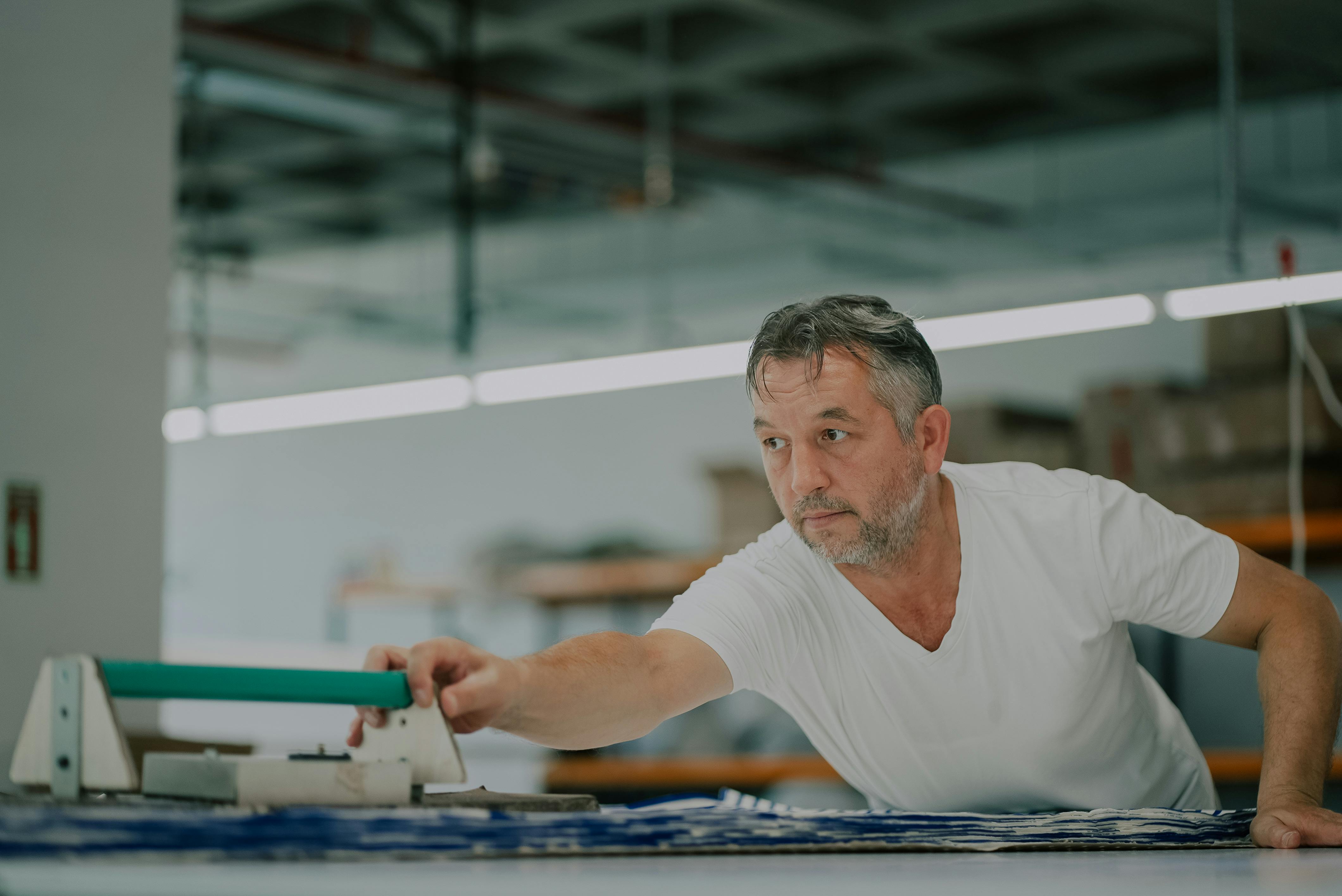 Man Working with Fabric in Workshop · Free Stock Photo