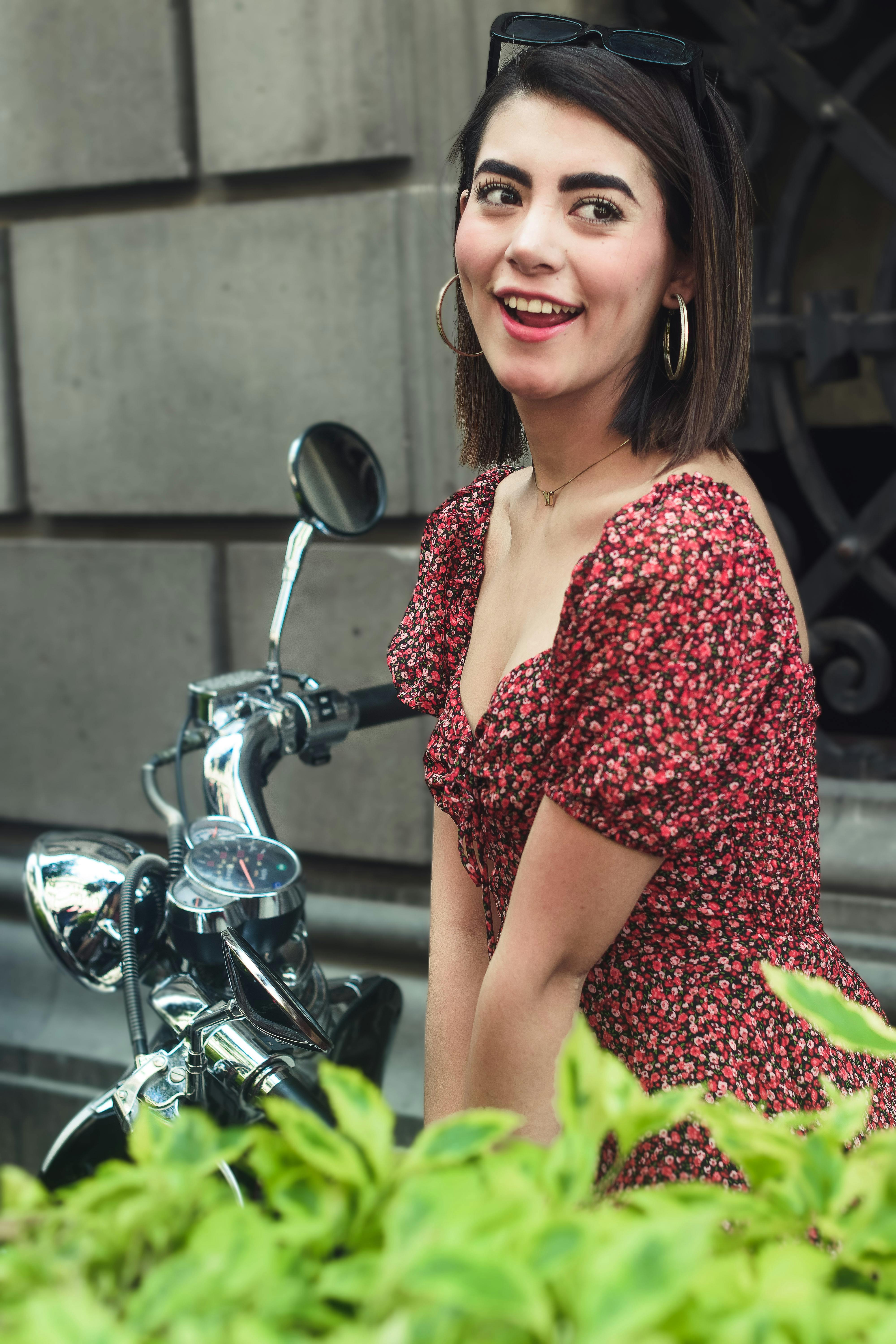 Woman in Red Floral Dress Sitting on Motorcycle · Free Stock Photo