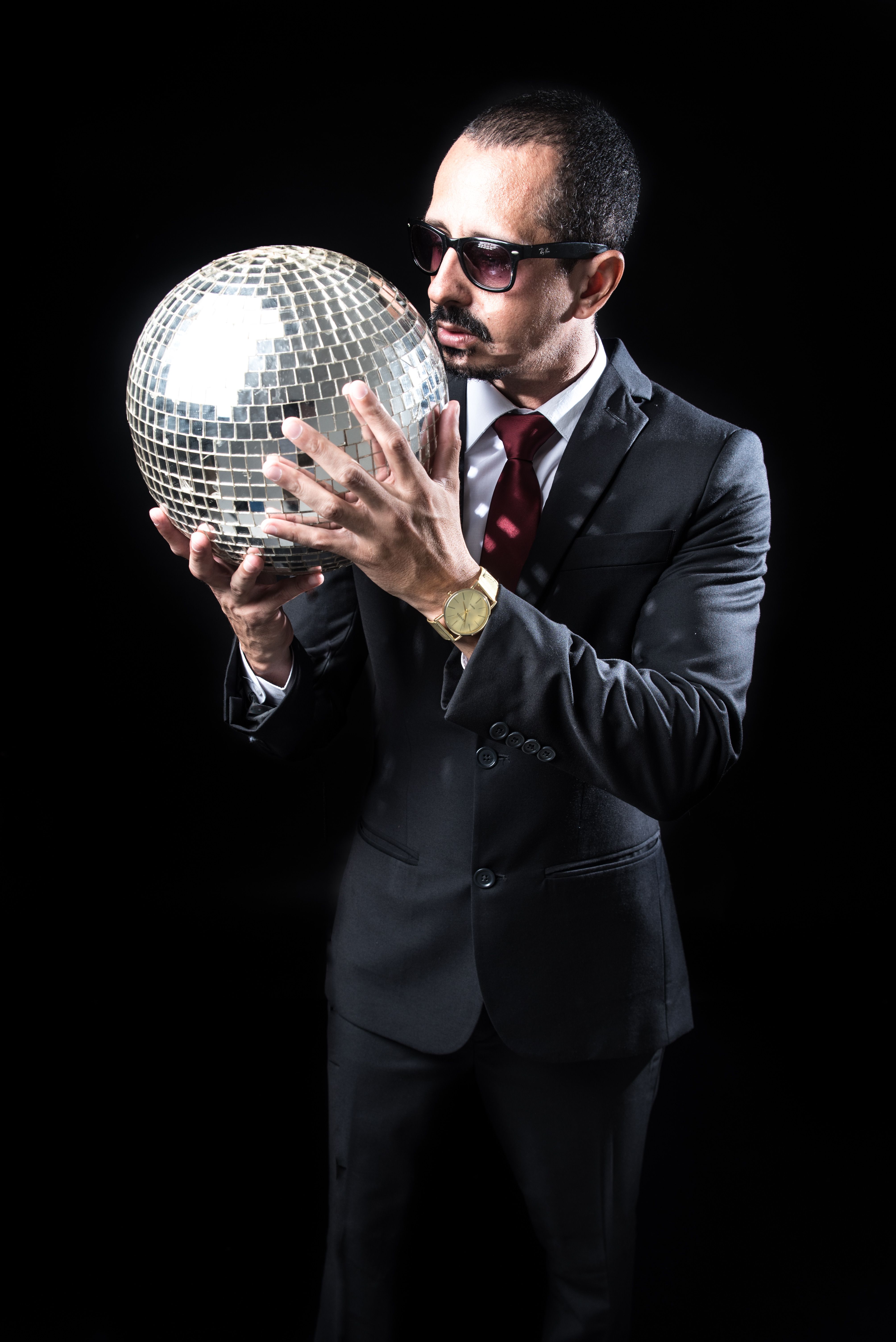 A Man in a Black Suit Holding A Disco Ball · Free Stock Photo