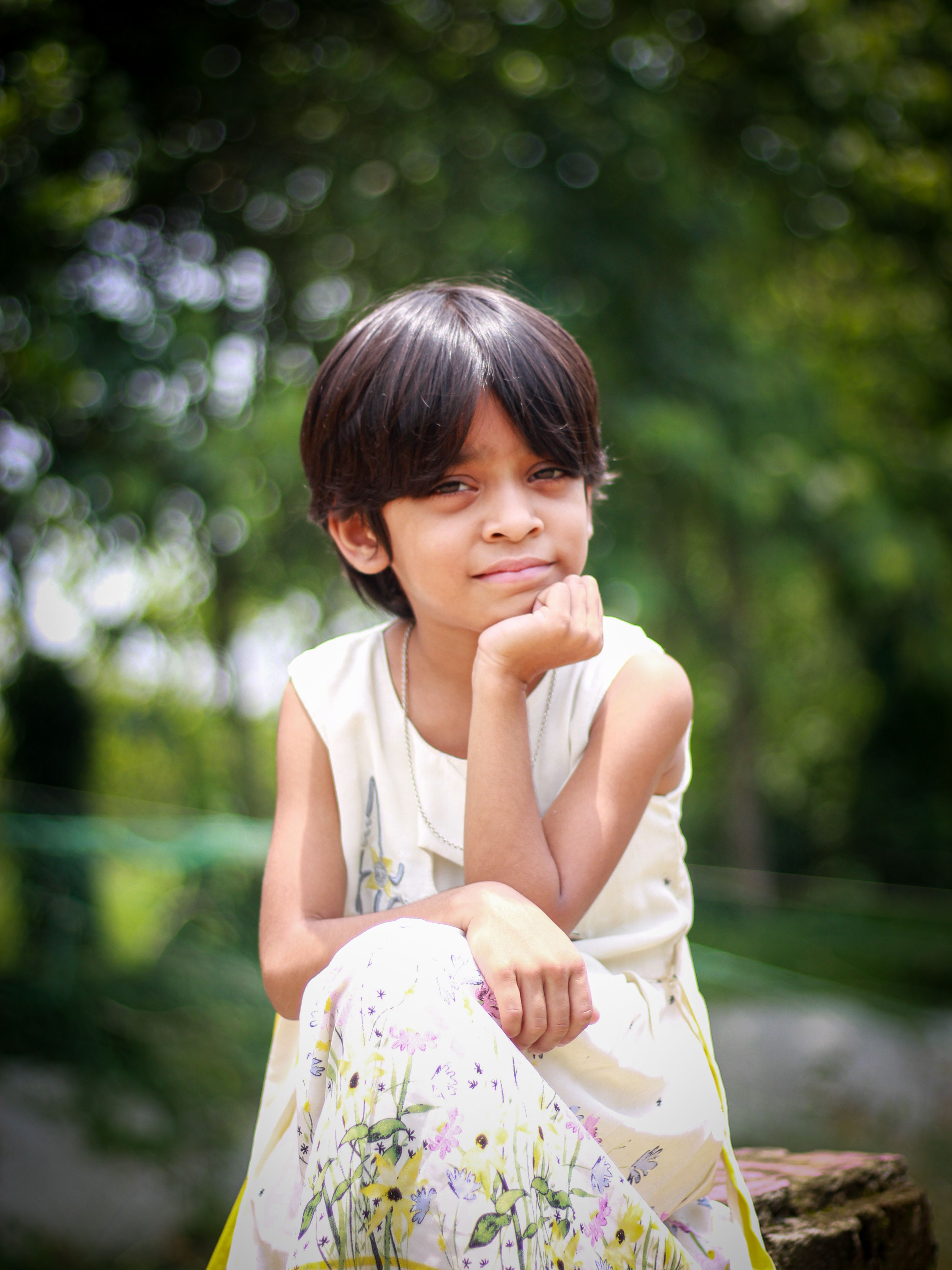 Photo of a Kid Posing with Her Hand on Her Chin · Free Stock Photo