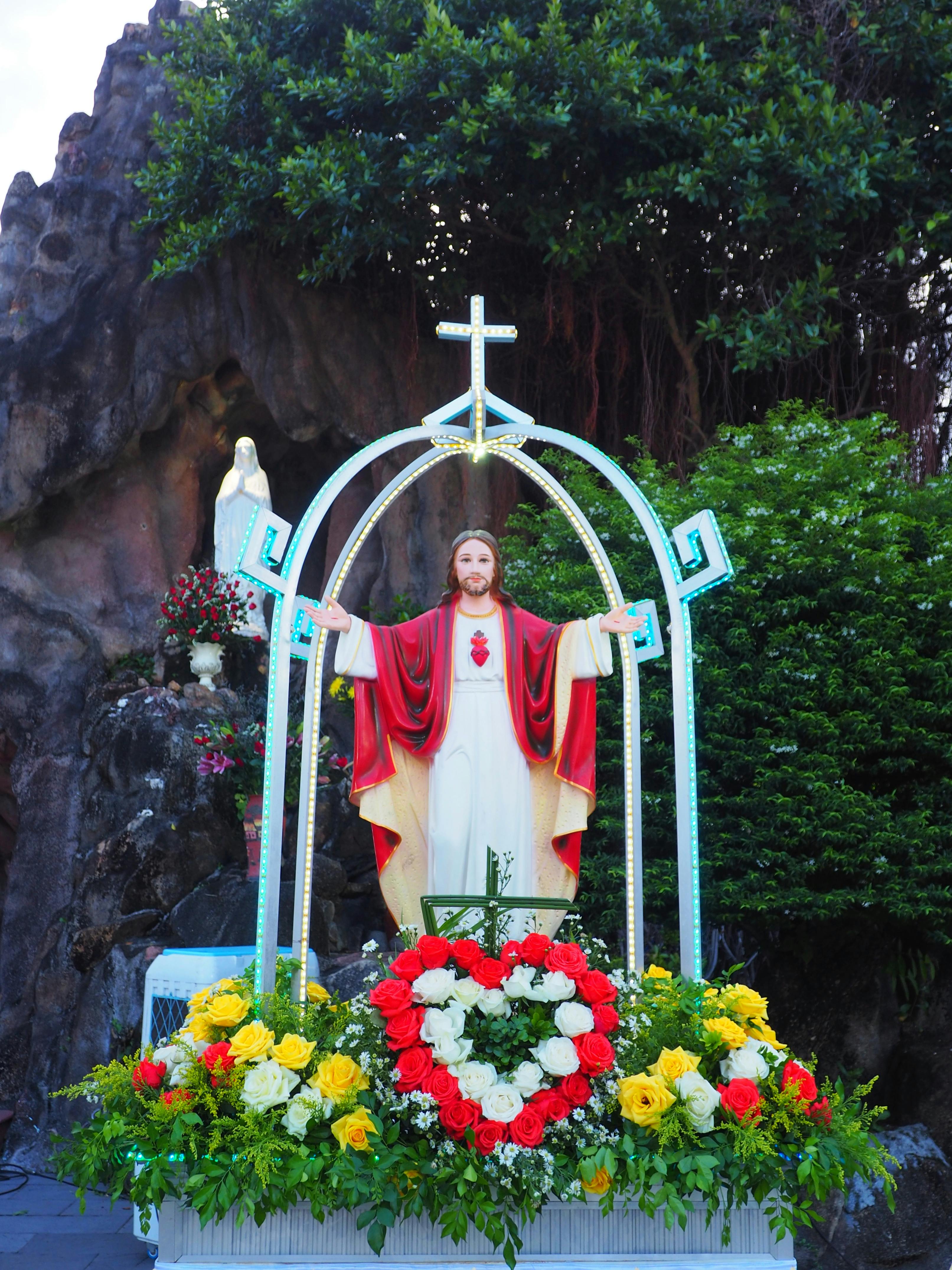 Jesus Christ Statue with Flower Arrangement · Free Stock Photo