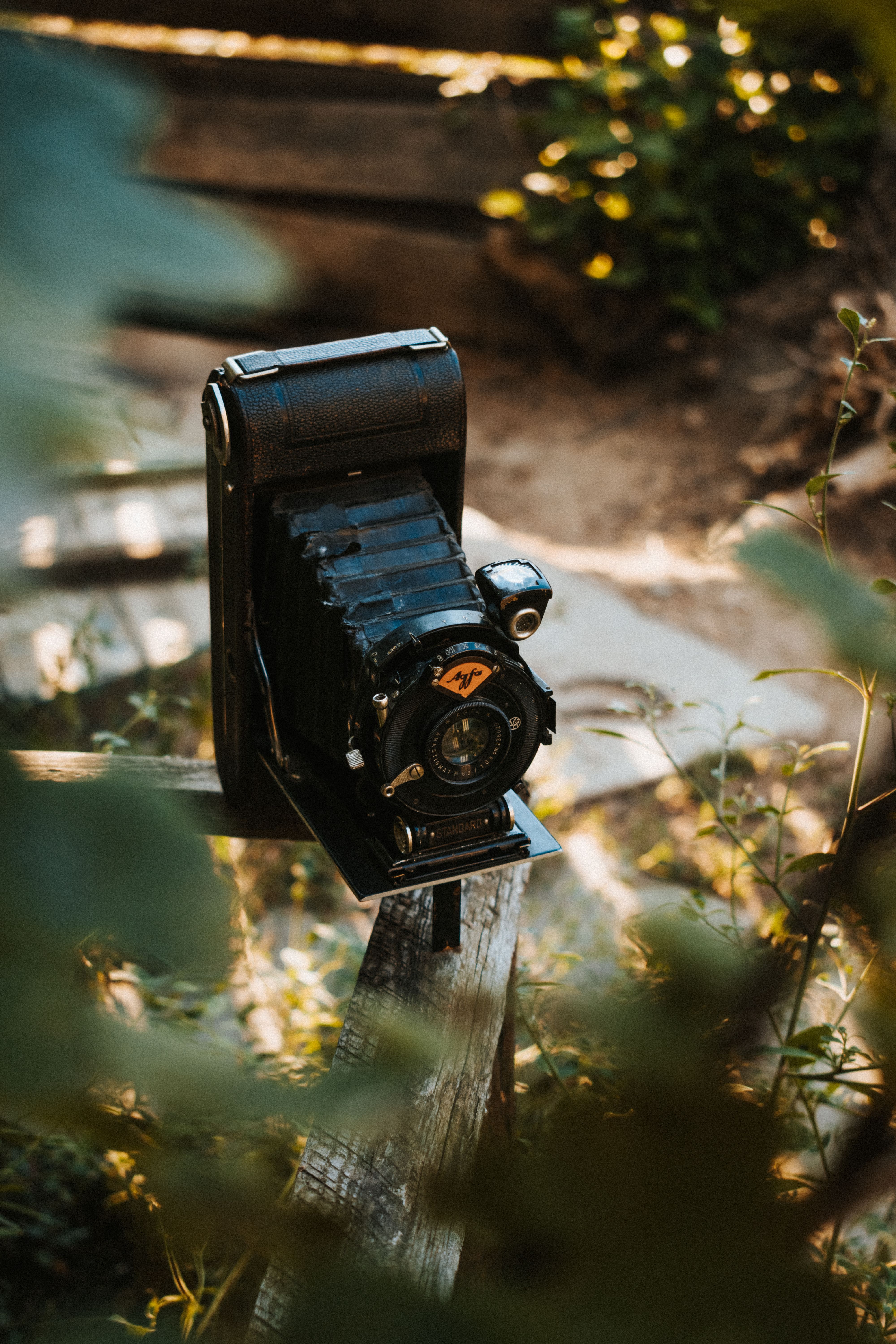 Black Old Camera on a Wooden Railing · Free Stock Photo