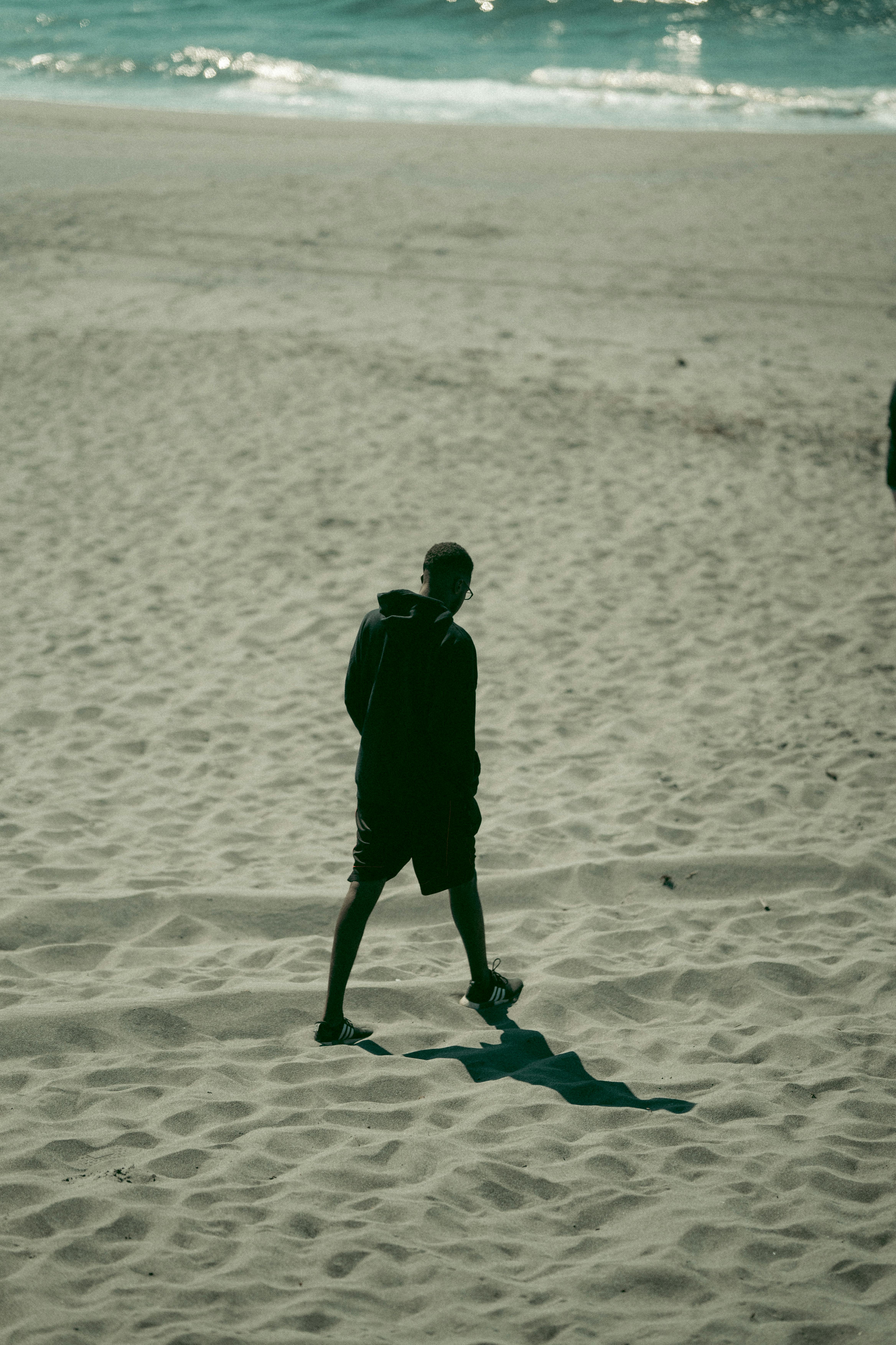 Photo of a Man Walking on Sand · Free Stock Photo