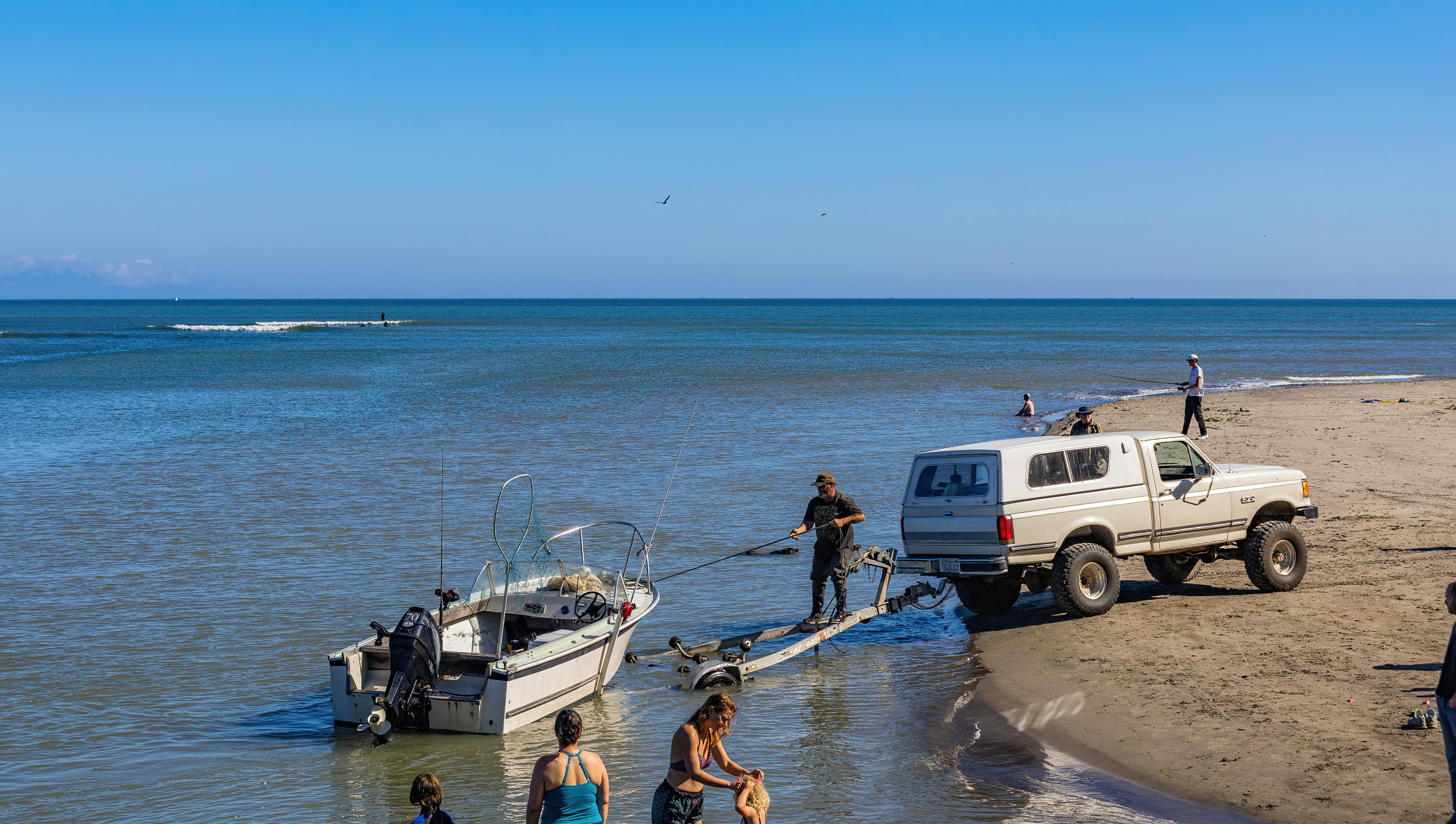 People Taking a Boat out of the Water with a Car · Free Stock Photo