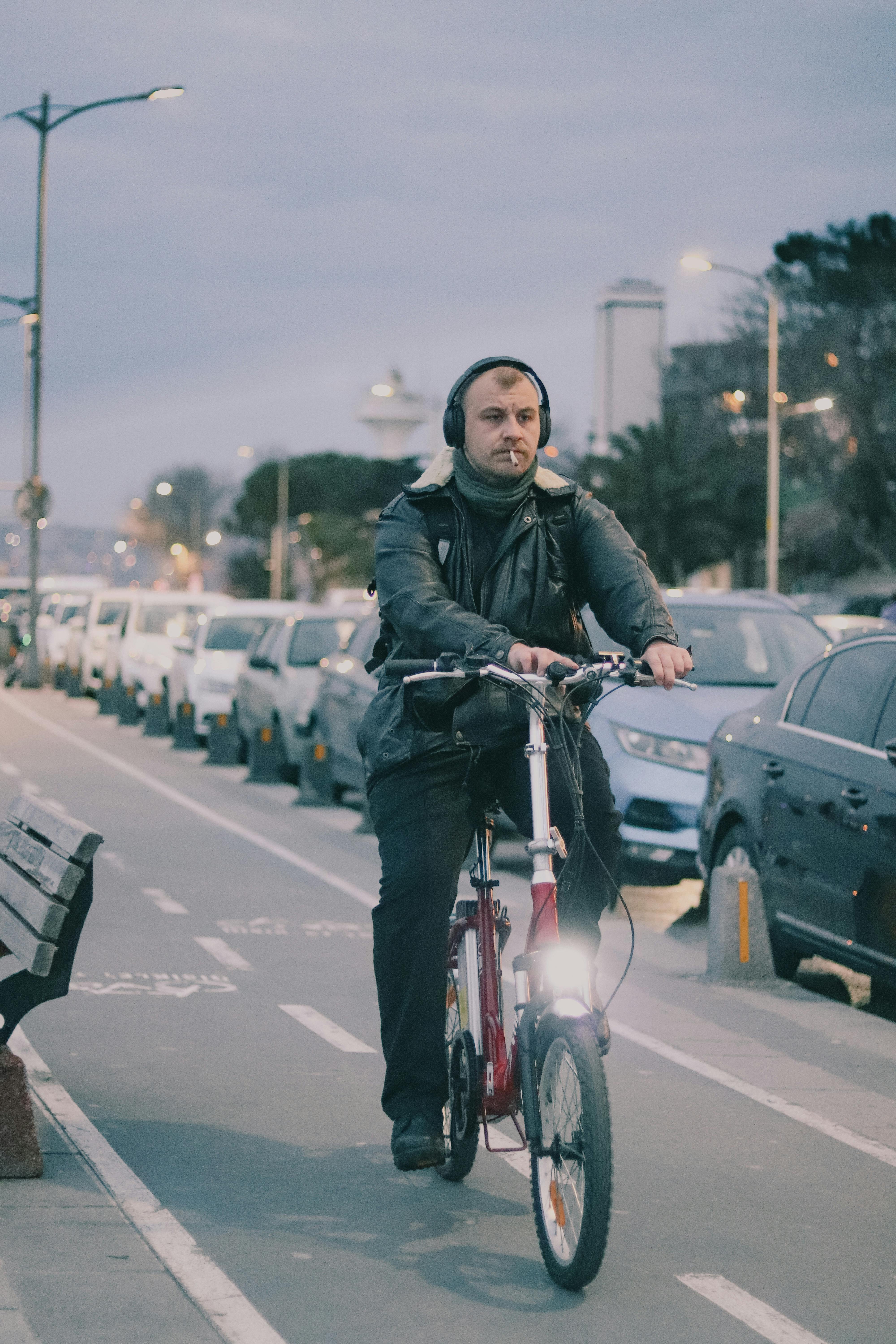A Cameraman Filming a Man Wearing Raincoat while Riding a Bike · Free ...