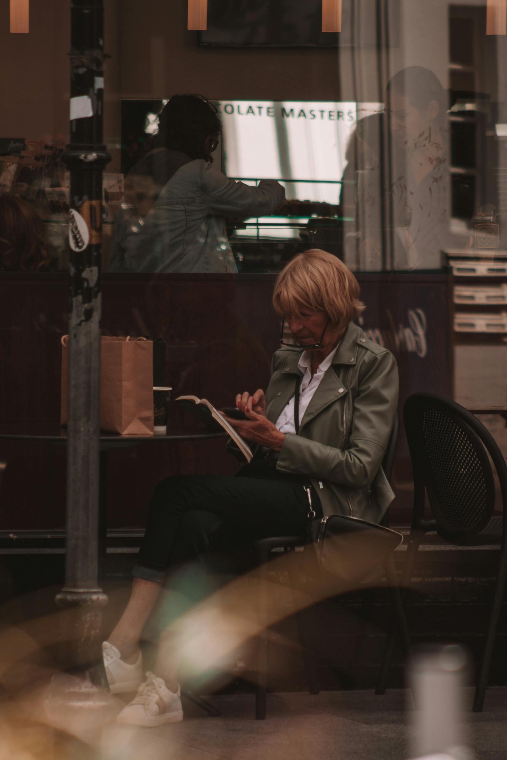 Woman Sitting in Cafe Reading Book · Free Stock Photo