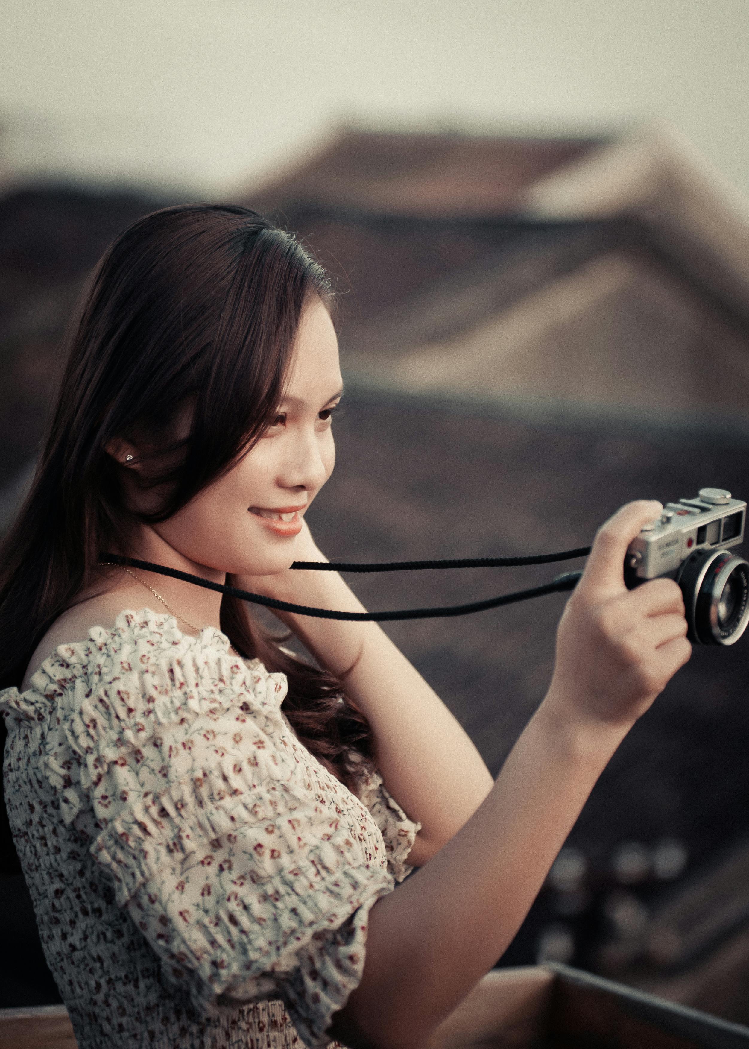 Woman Holding a Camera in front of Her Face · Free Stock Photo
