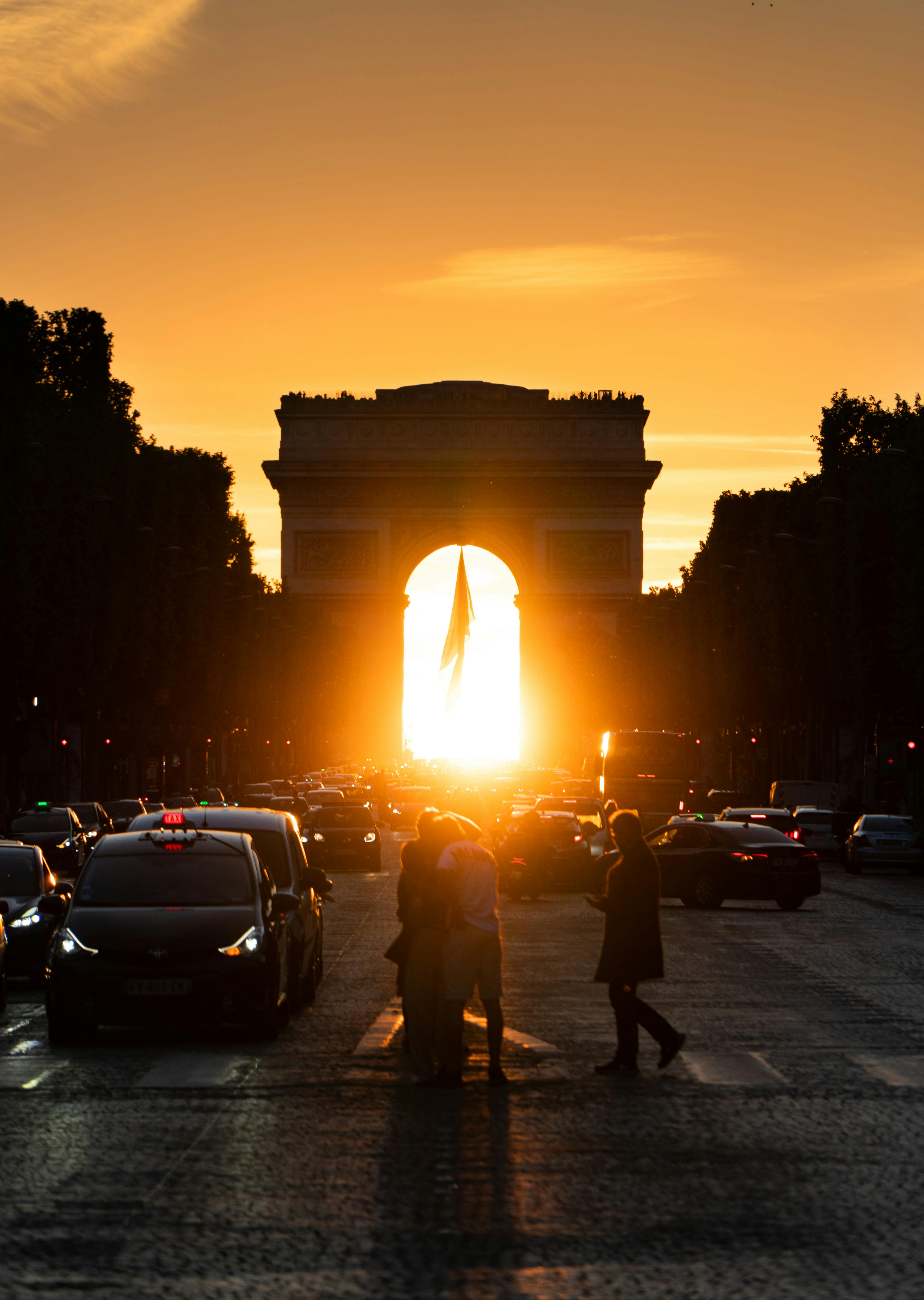 Sunlight Shining Through Arc de Triomphe at Sunset · Free Stock Photo