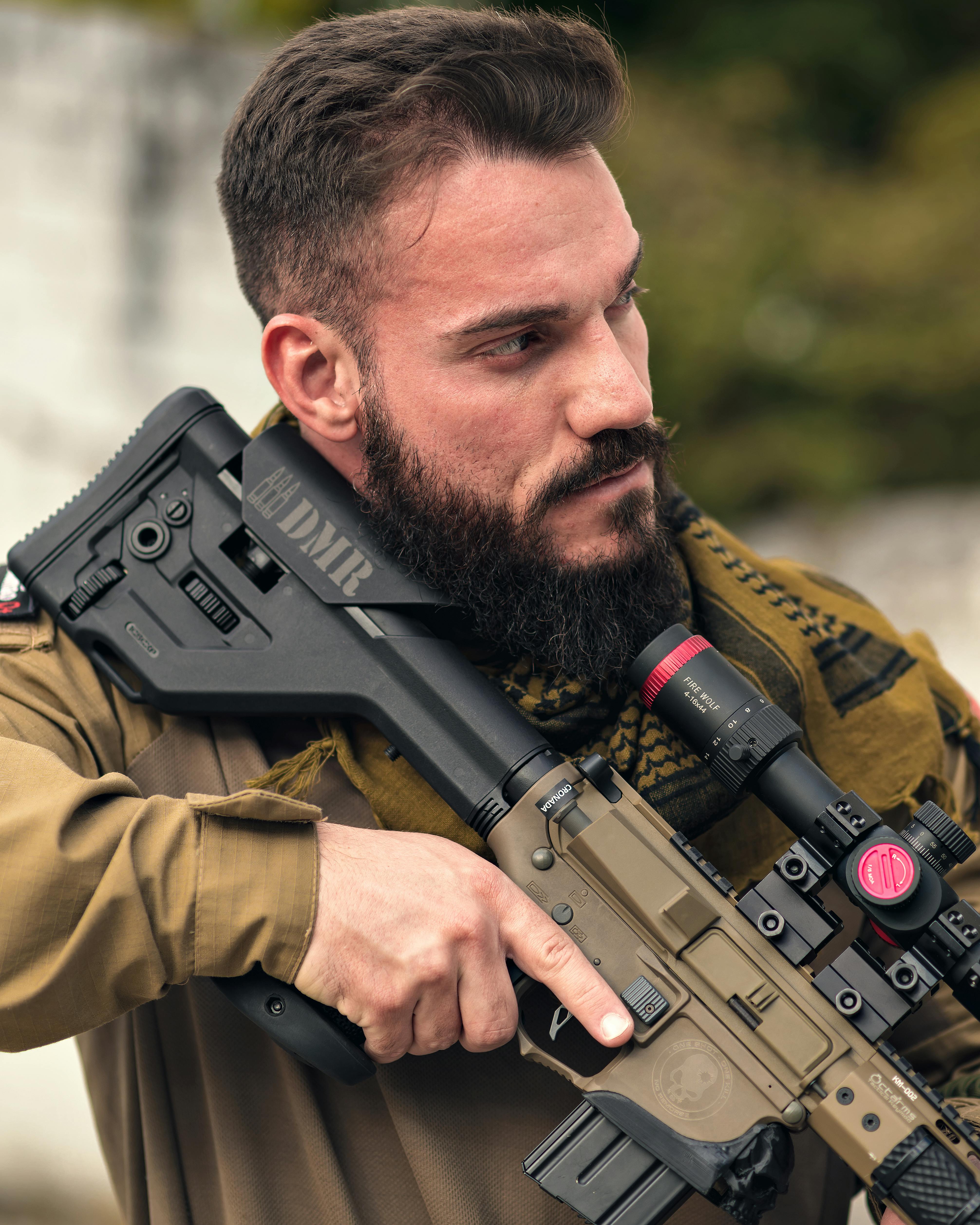 A Man in a Leather Vest Carrying a Rifle · Free Stock Photo