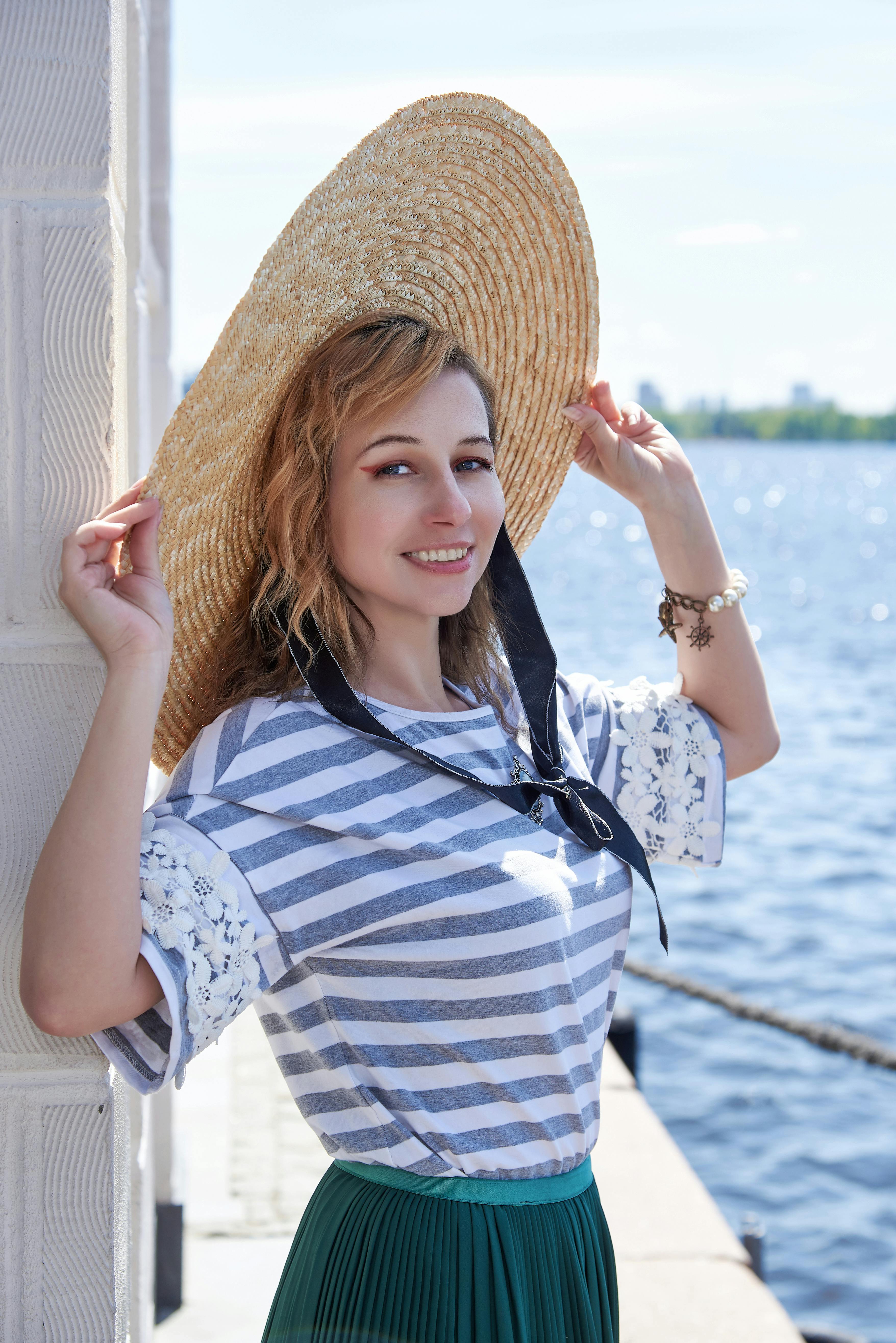 Young Woman Wearing a Big Round Hat on a Pier · Free Stock Photo