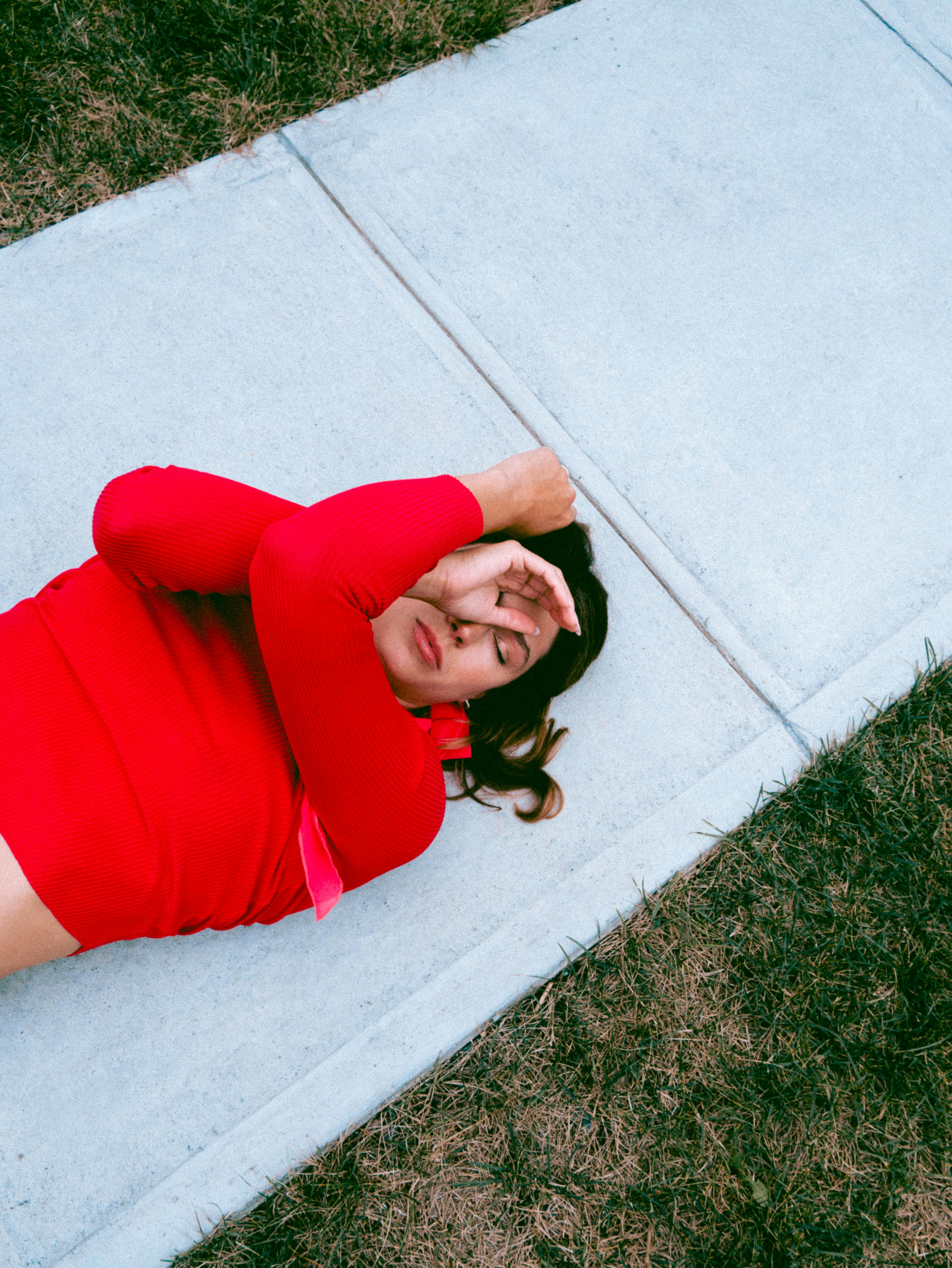 Woman in Knitted Sweater and Pants Lying Down on Bridge Over a Body of ...