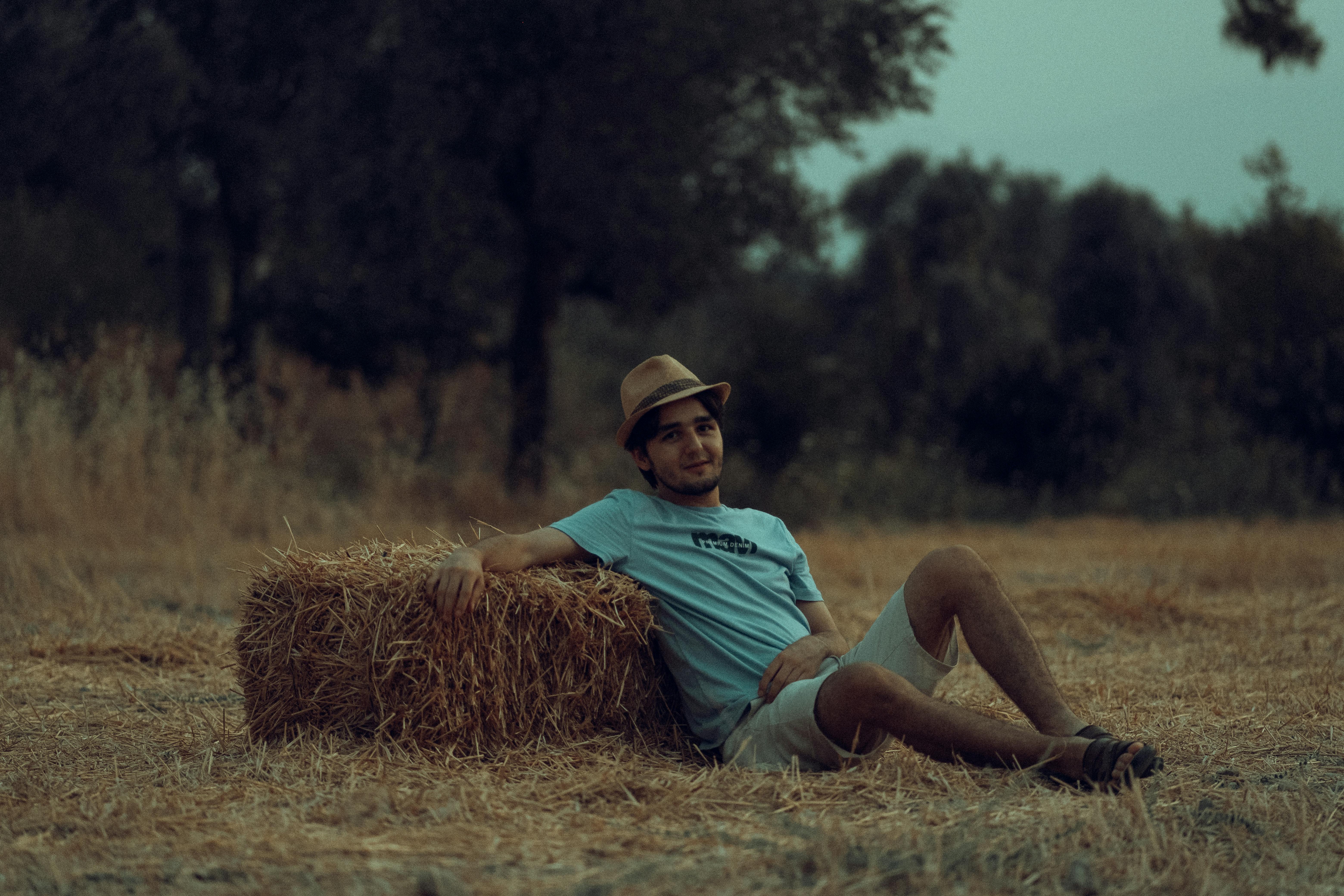 Man in a Shirt Leaning on a Hay Bale · Free Stock Photo