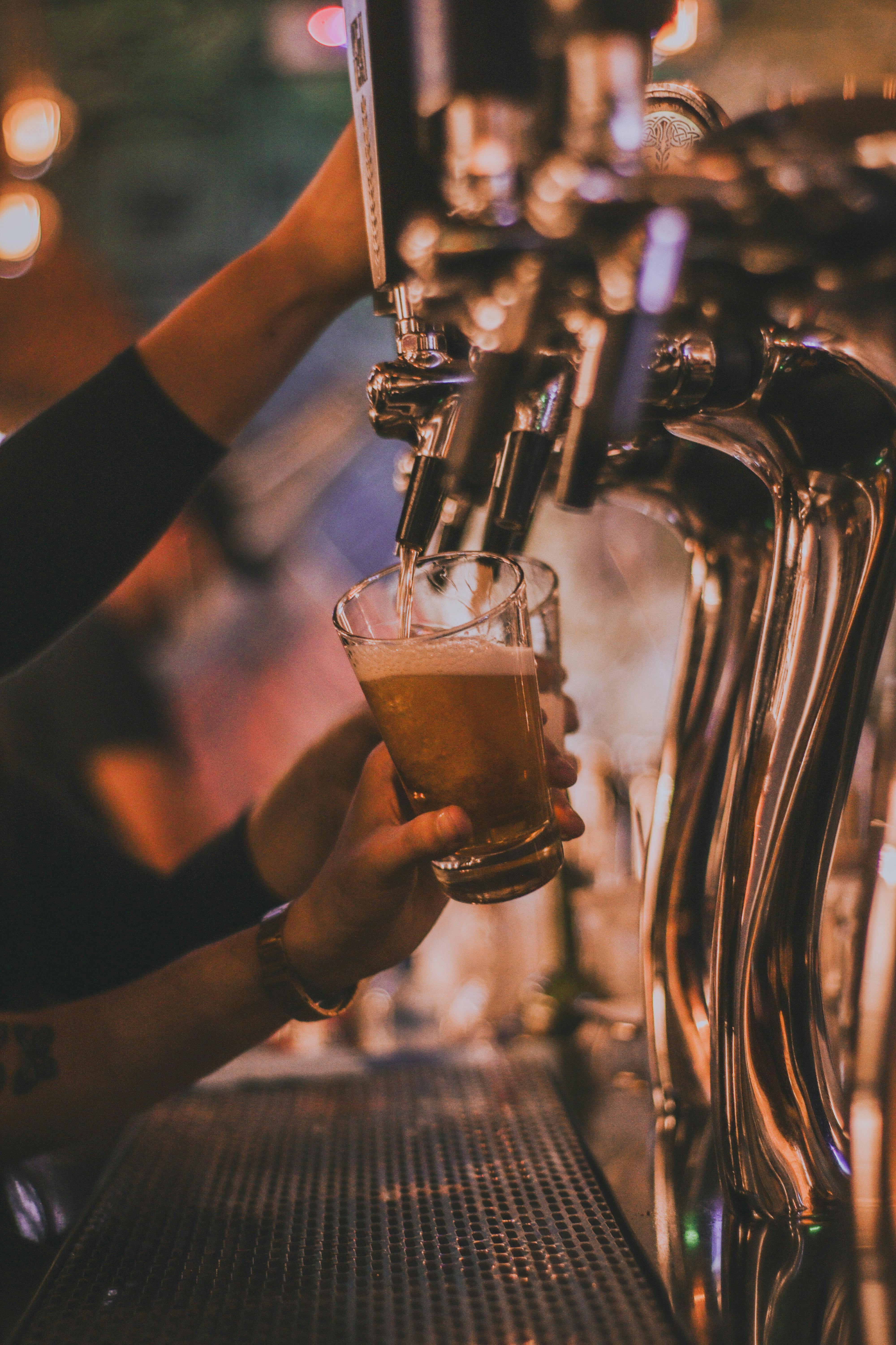 A Hand Refilling Beer on the Glass · Free Stock Photo