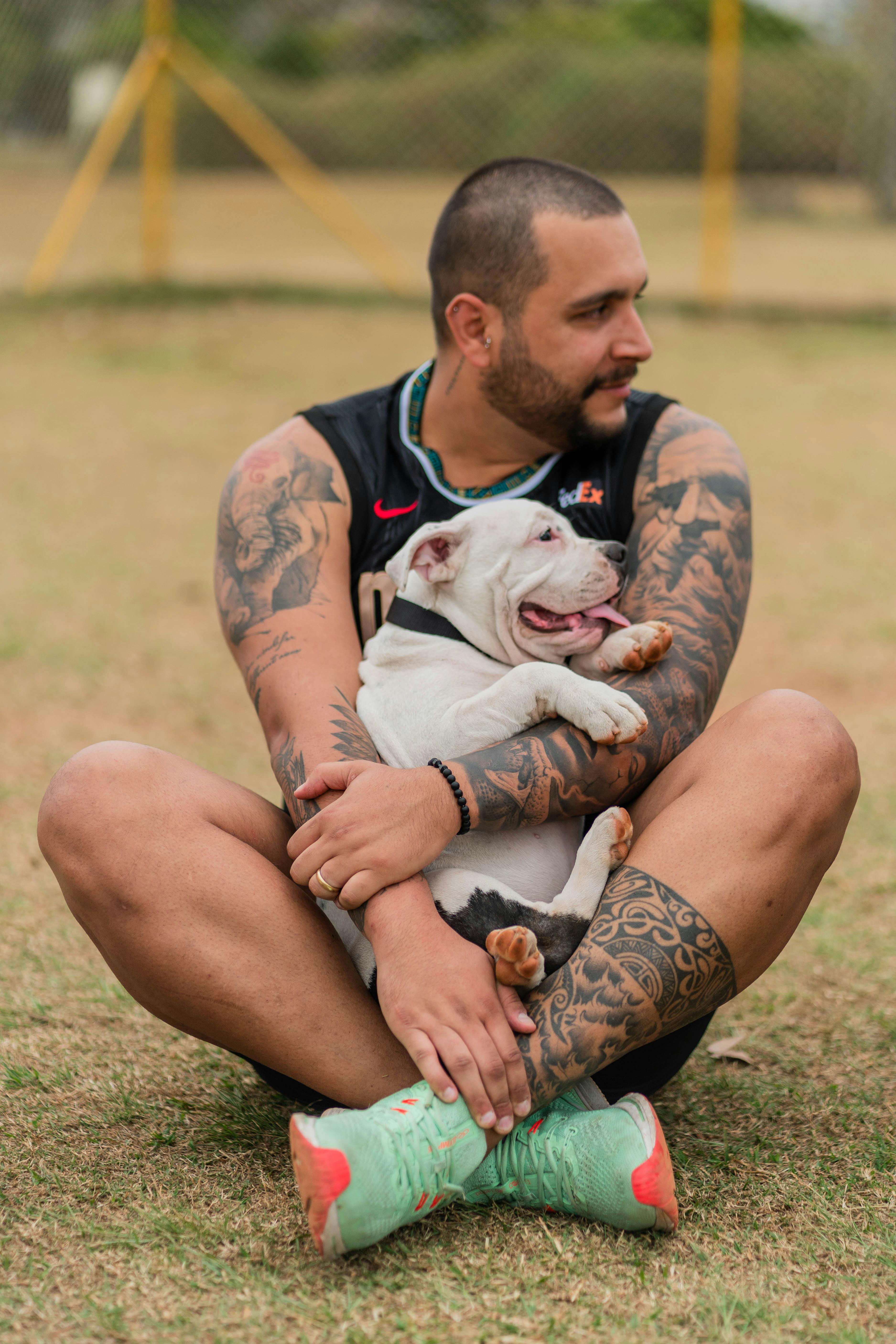 Man Sitting on the Ground Cuddling His Dog · Free Stock Photo