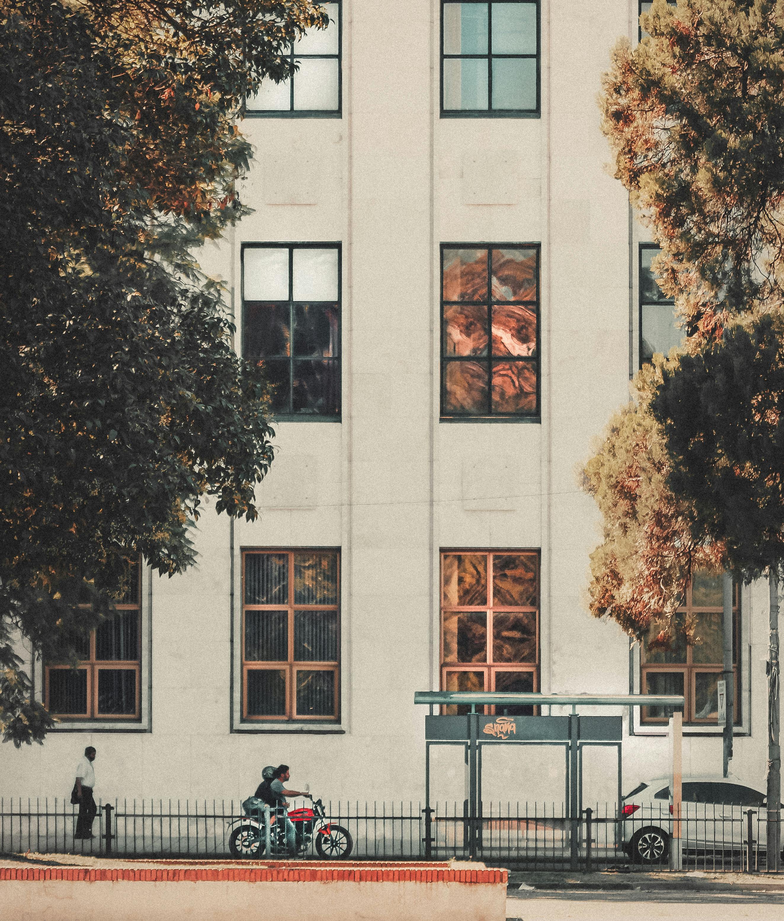 People Riding a Motorcycle Passing a Building · Free Stock Photo