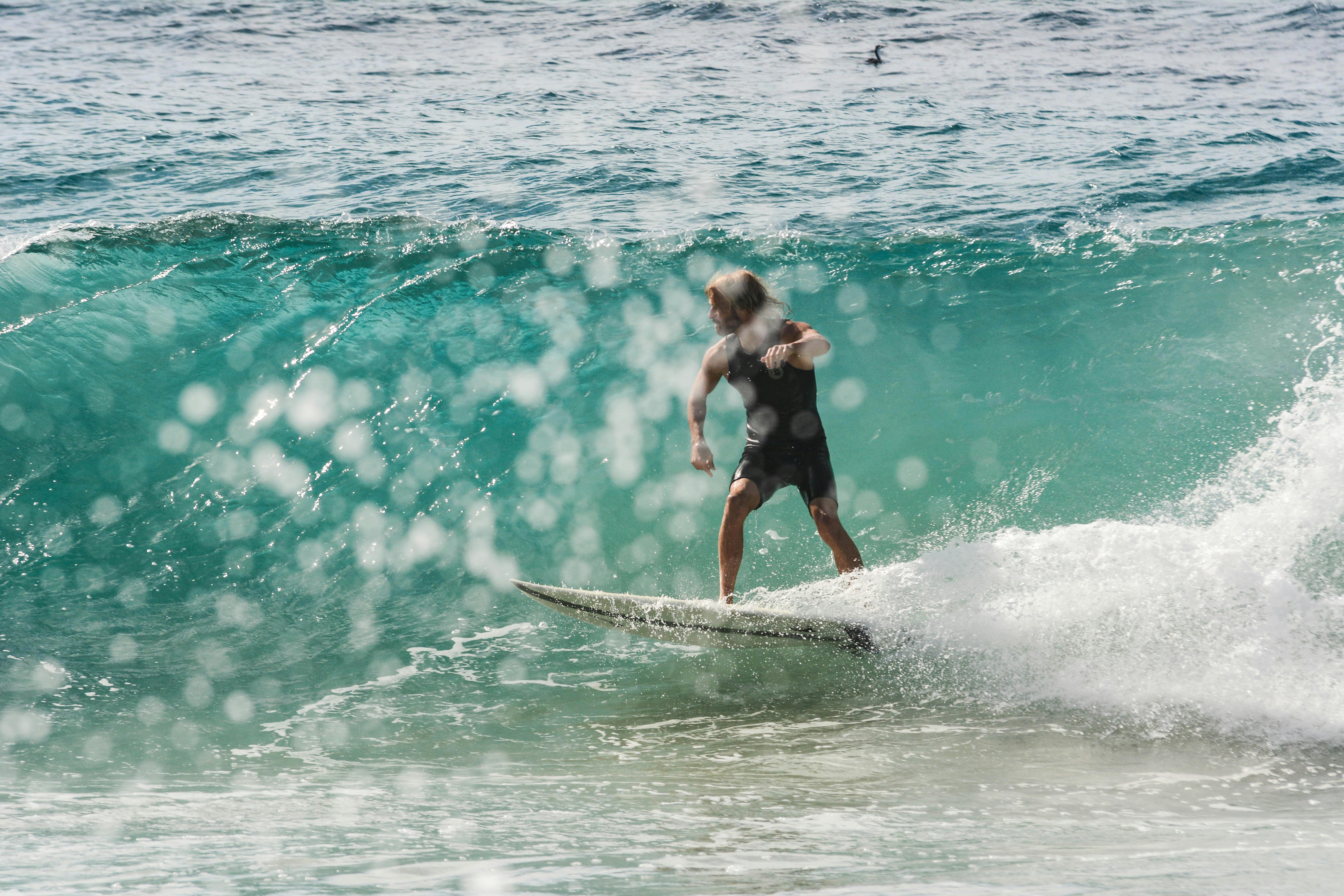 Man Riding White Surfboard · Free Stock Photo
